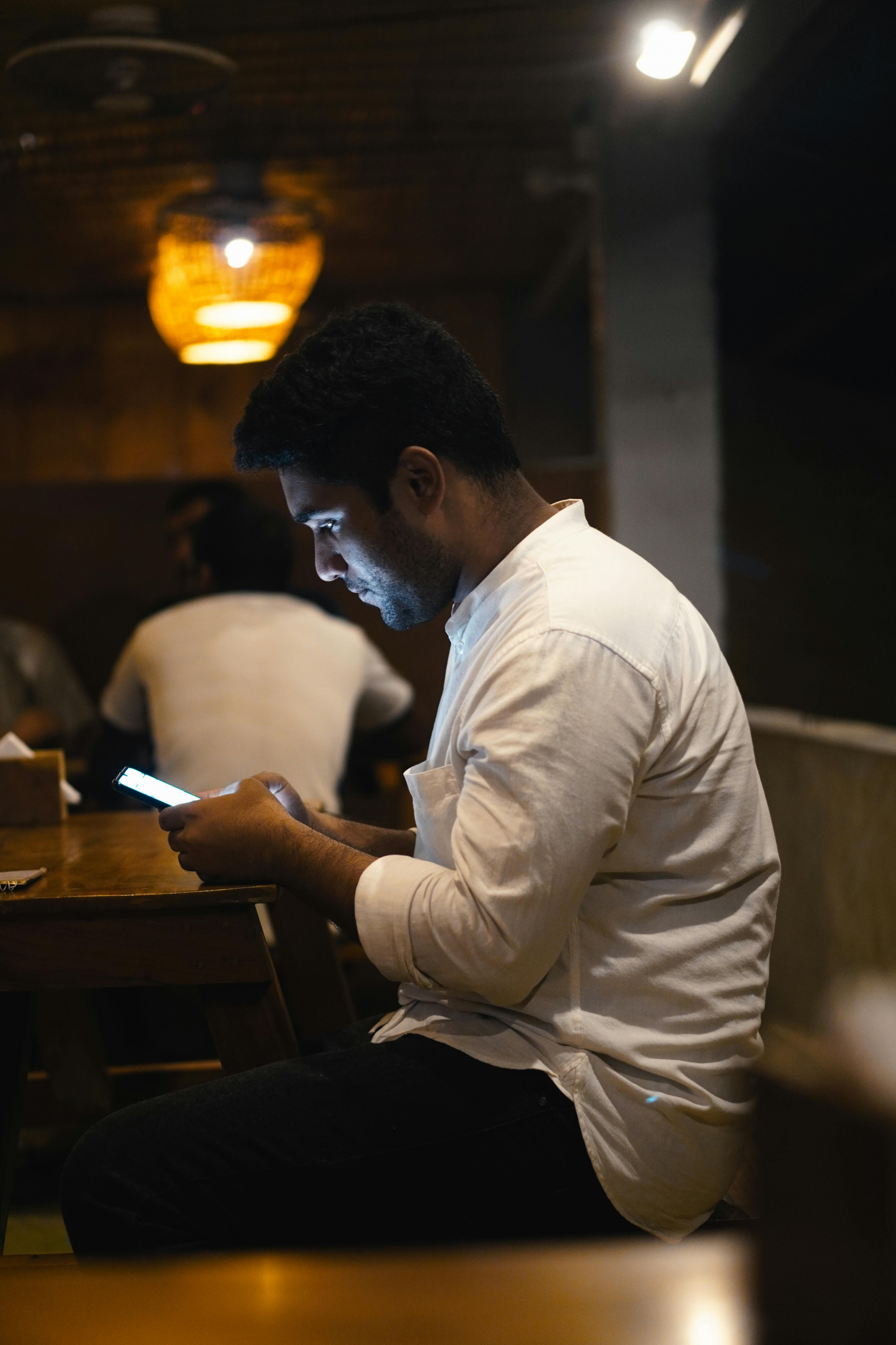 Man Sitting by Table with Accessories · Free Stock Photo