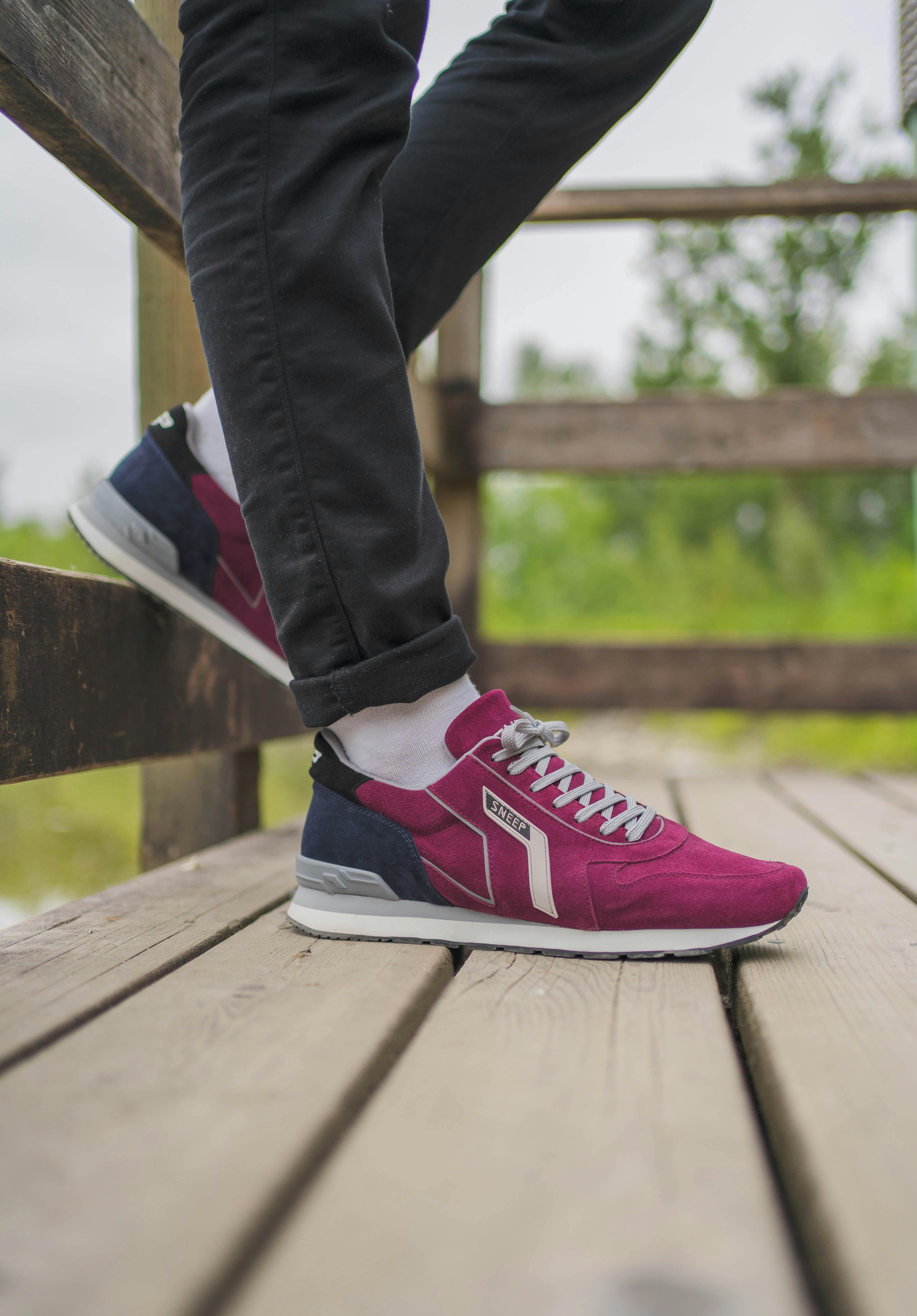 A Person Wearing Maroon Sneep Crew Sneakers · Free Stock Photo