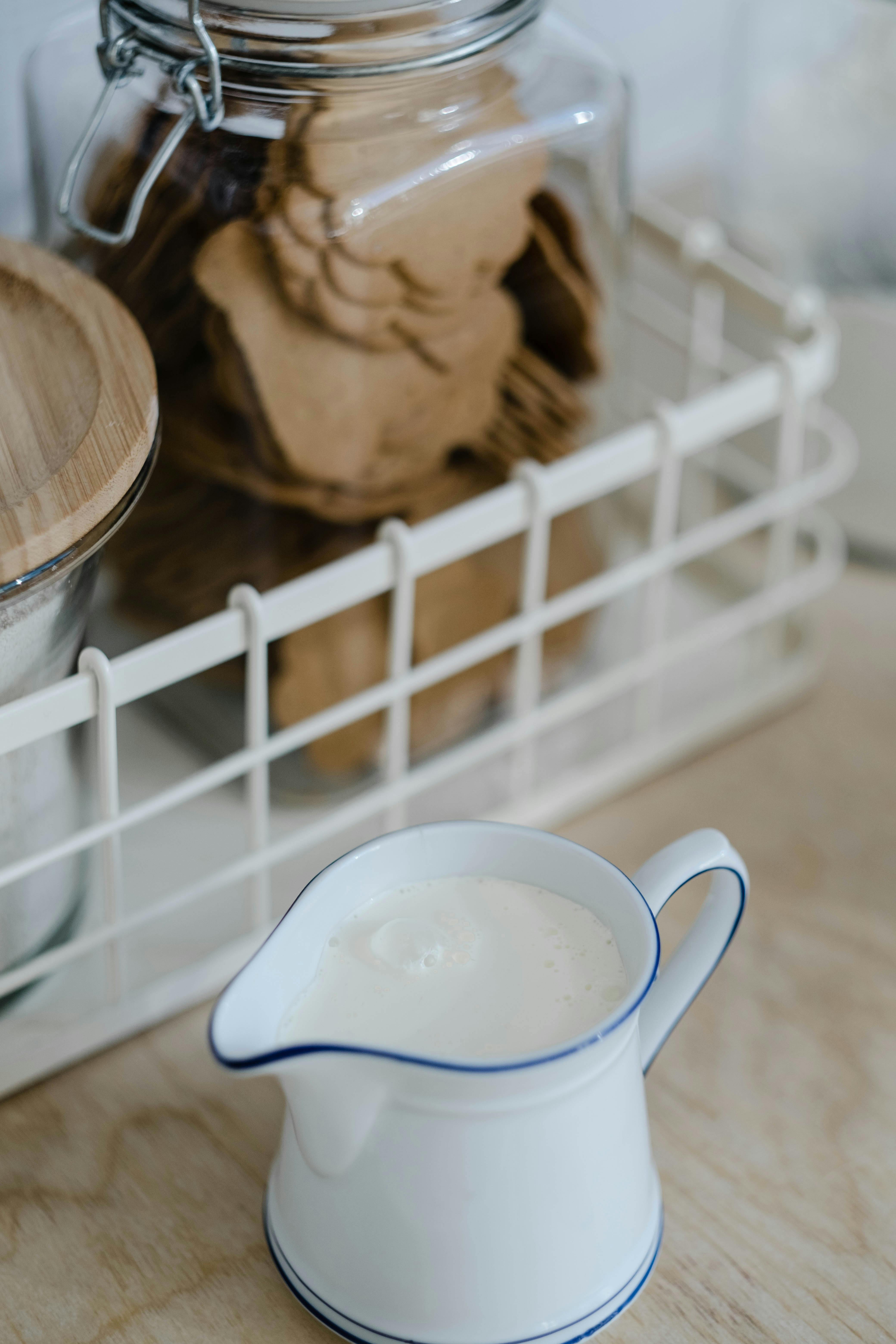 Close-Up Shot of a White Ceramic Pitcher beside a Jar of Cookies · Free ...