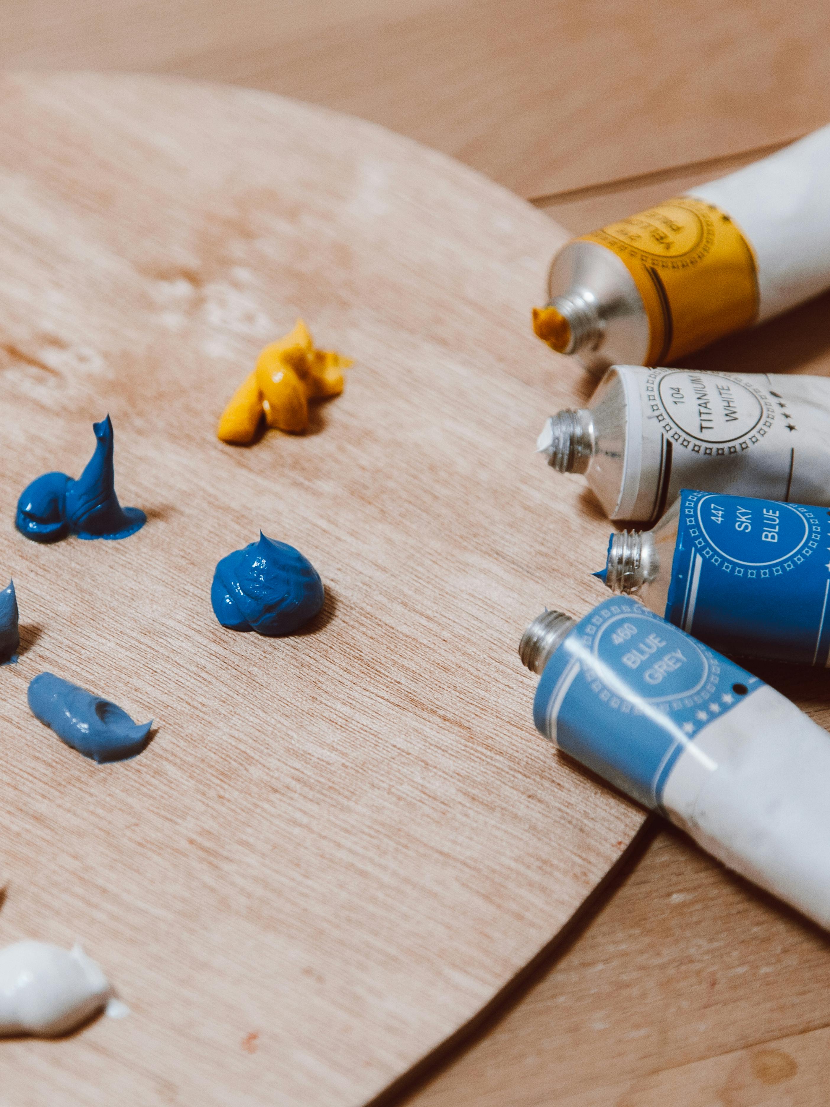 Yellow and Blue Paint on a Wooden Color Palette · Free Stock Photo