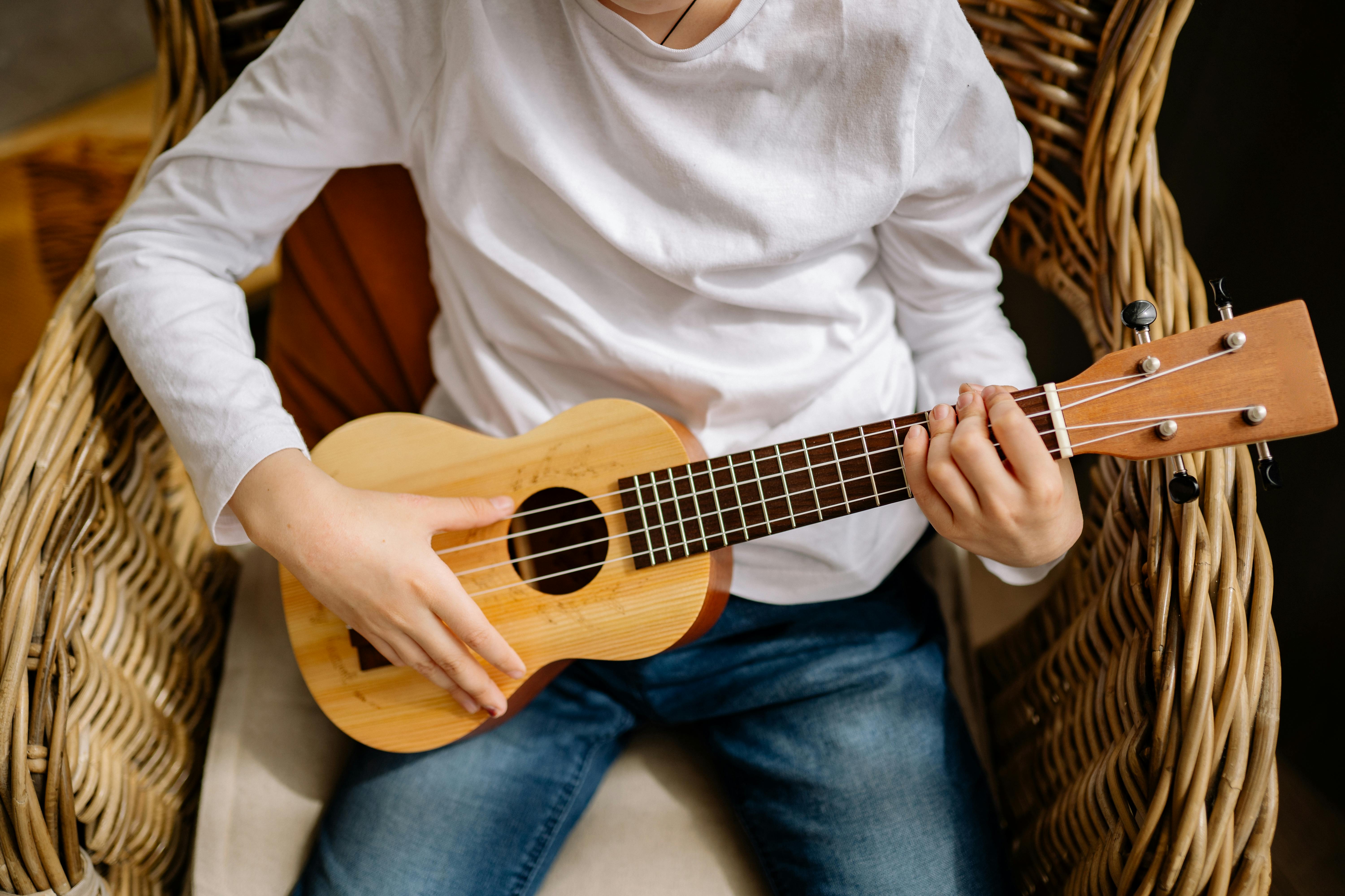 A Child Playing an Ukulele · Free Stock Photo