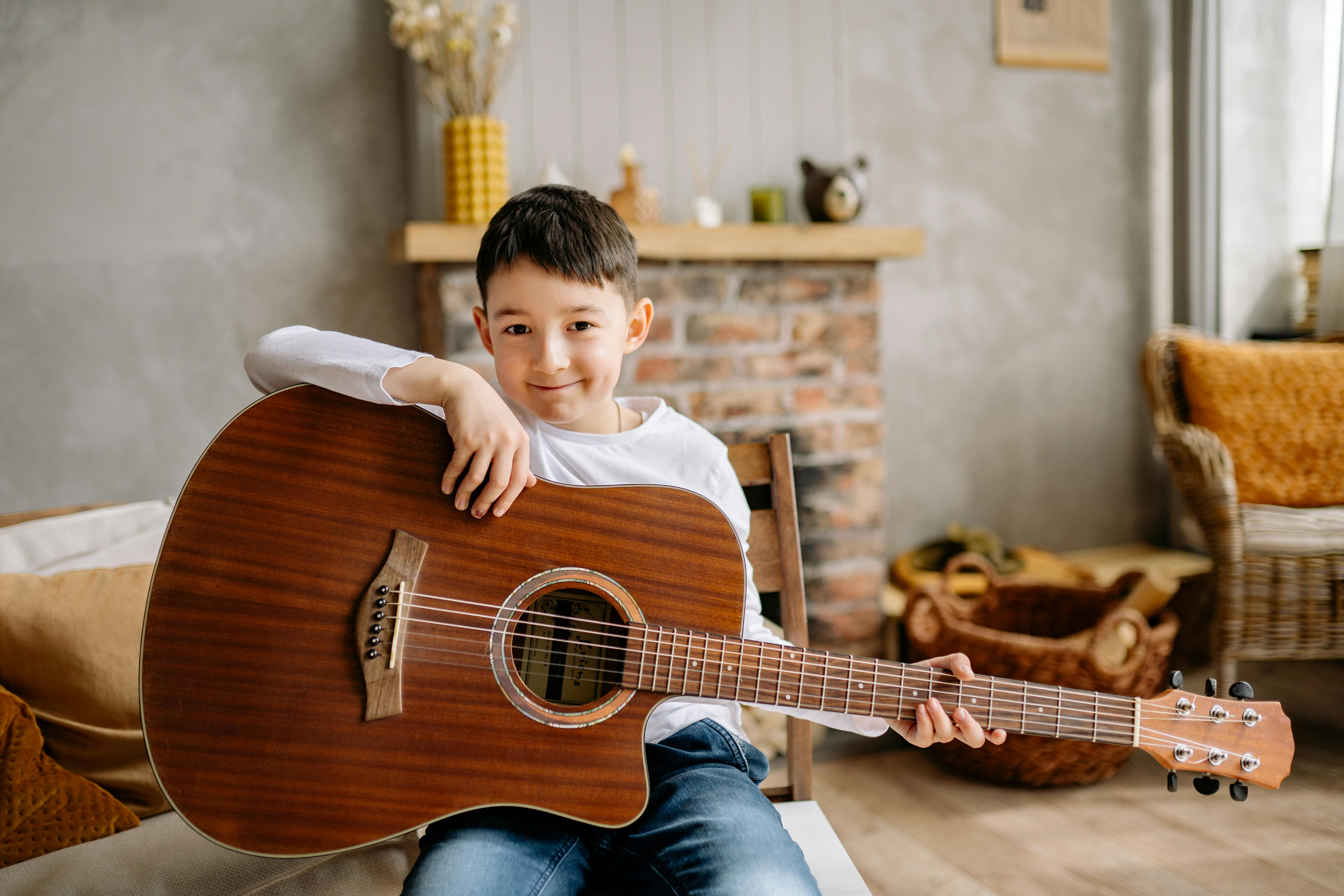kid Holding an Acoustic Guitar · Free Stock Photo