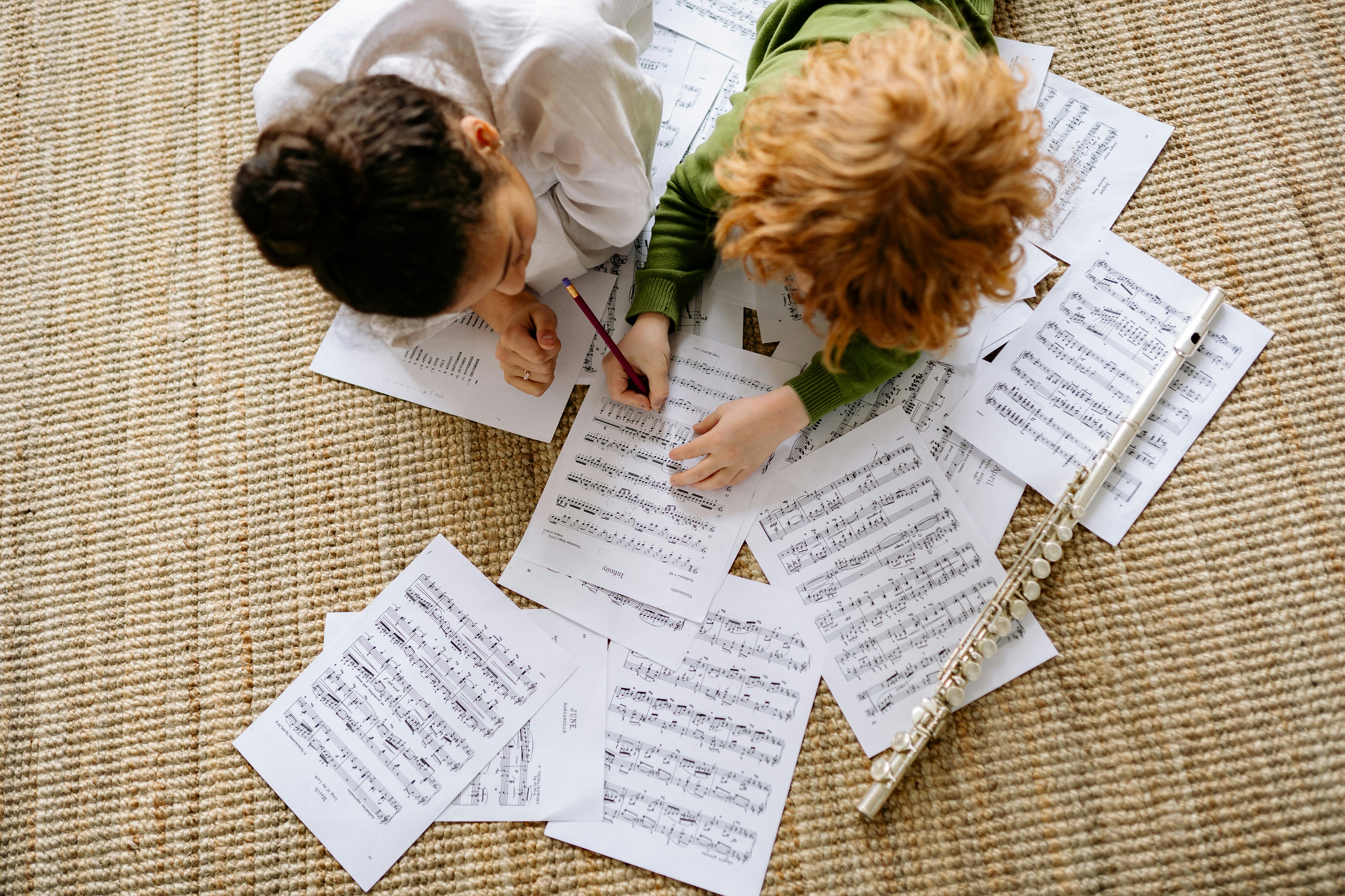 Woman and Child Studying Music Sheets · Free Stock Photo