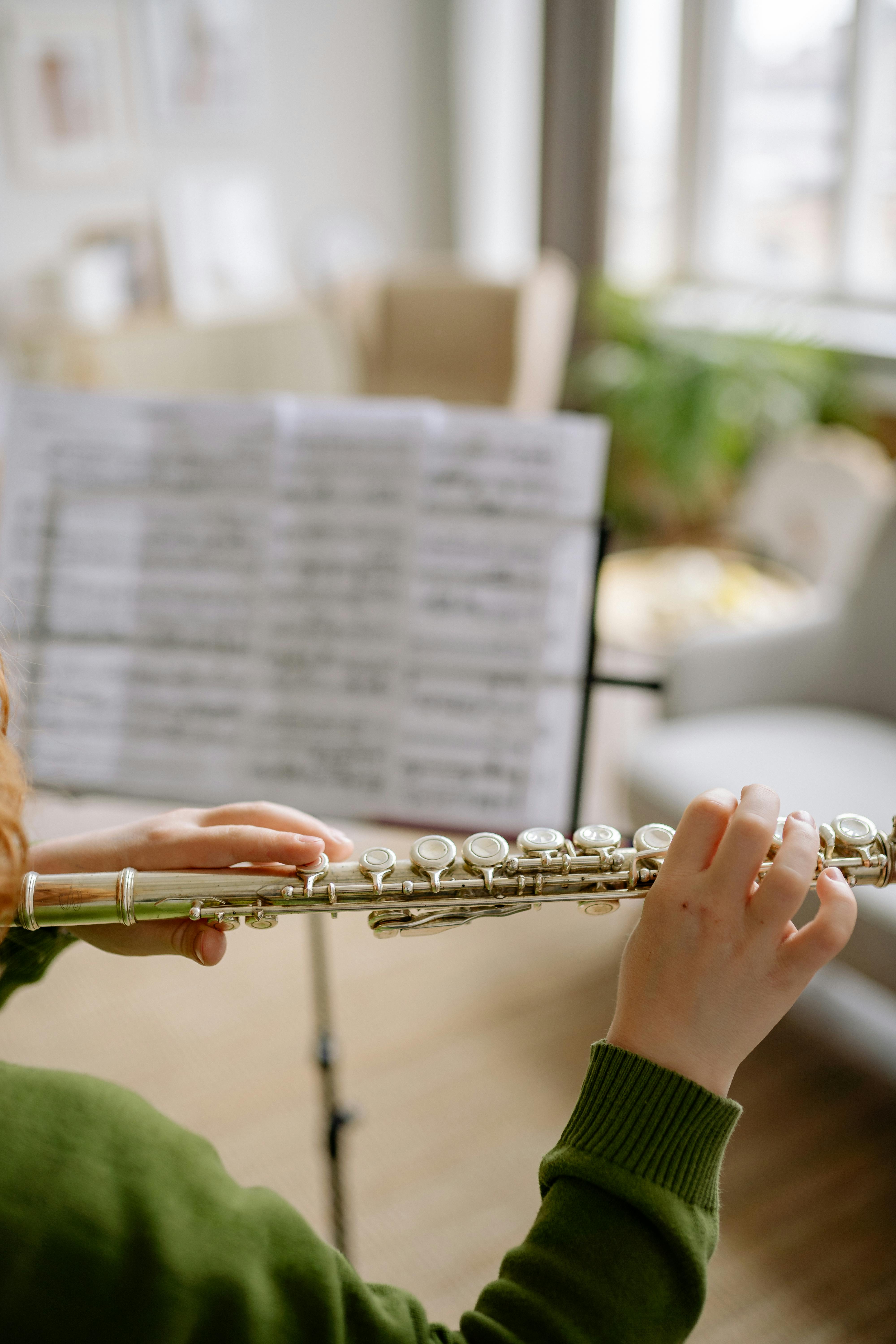 Person Playing Flute in Front of a Music Sheet · Free Stock Photo