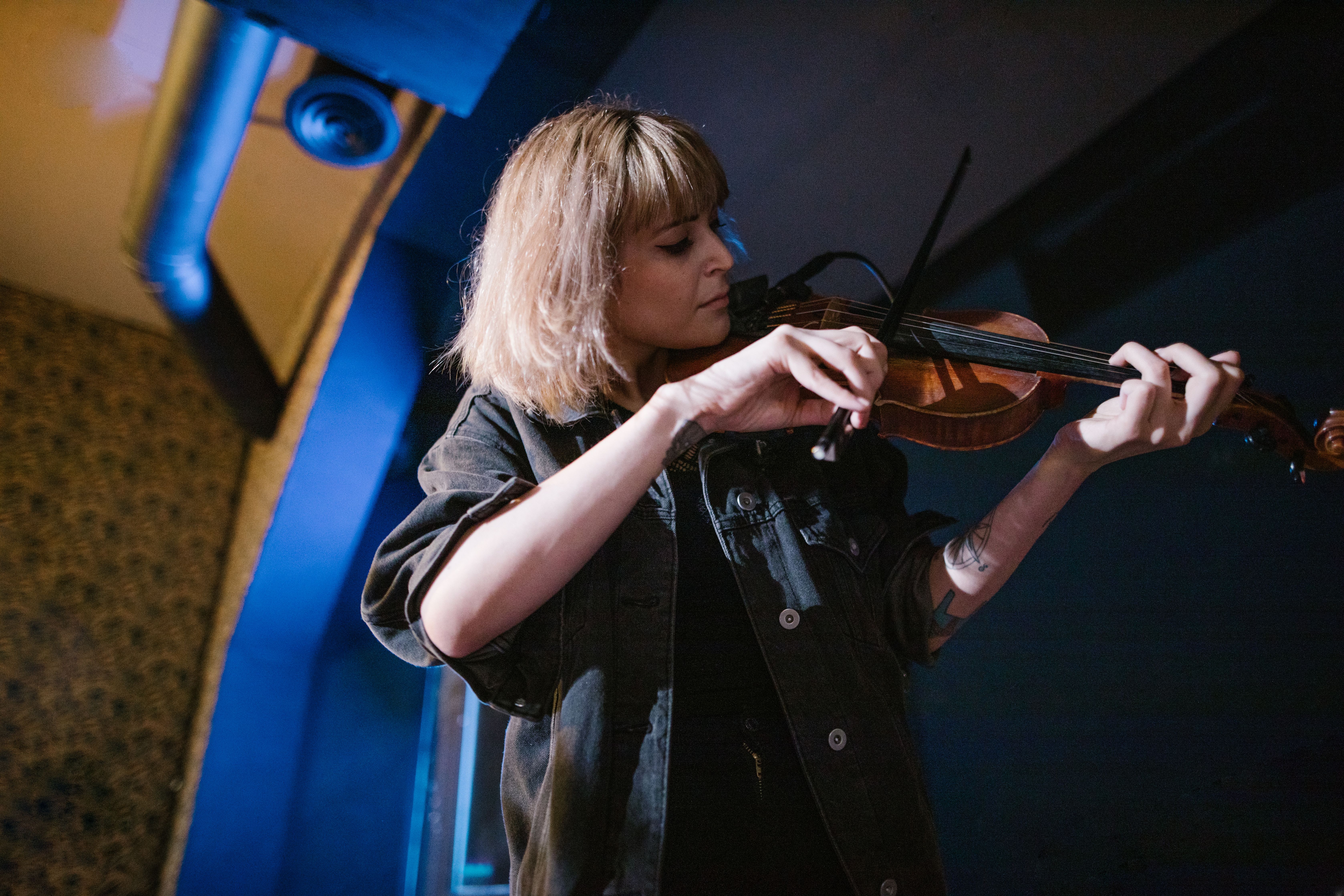 A Woman in Black Button Up Jacket Playing a Violin · Free Stock Photo