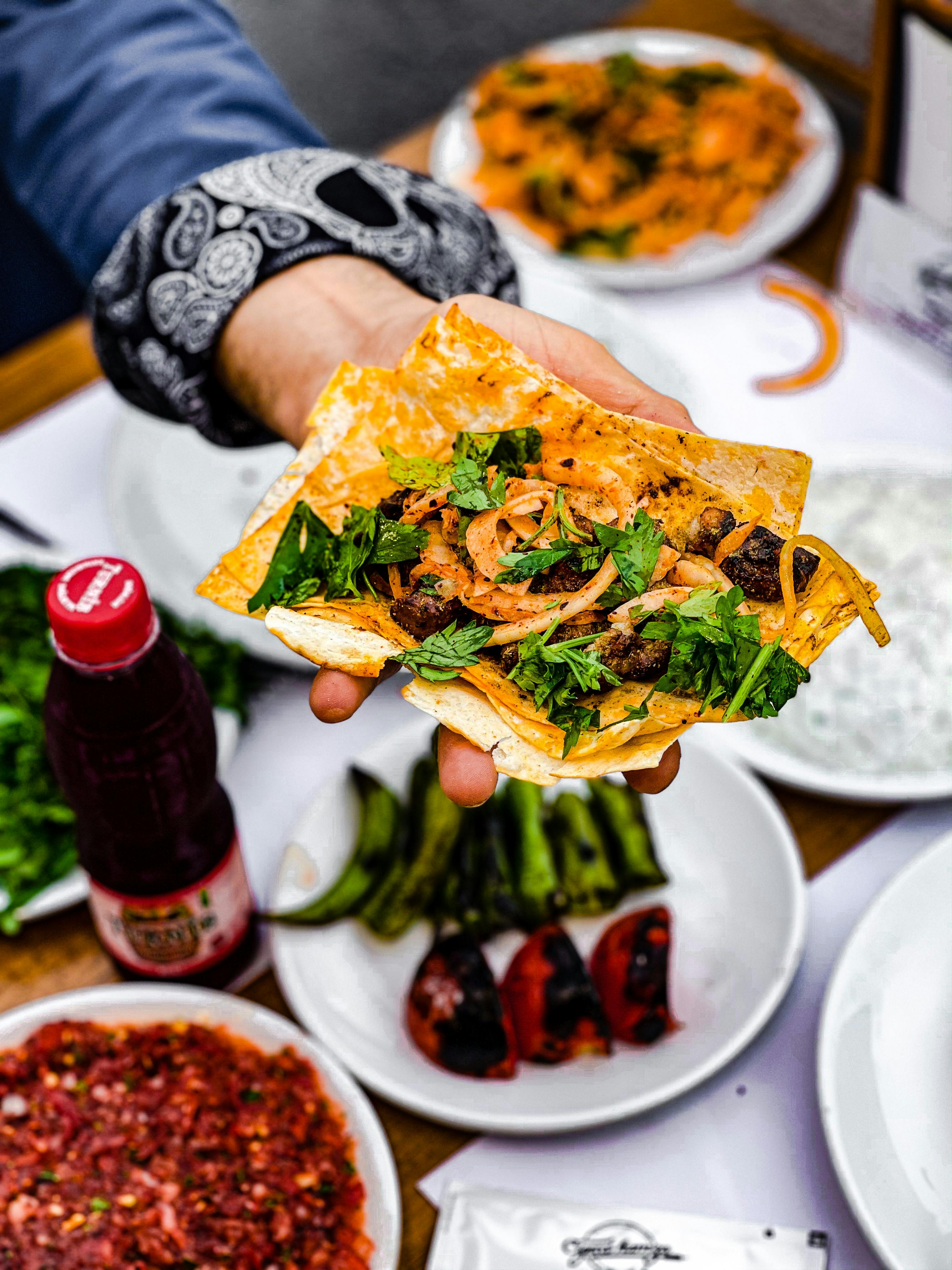 Close Up of Hand Holding Food on Feast · Free Stock Photo