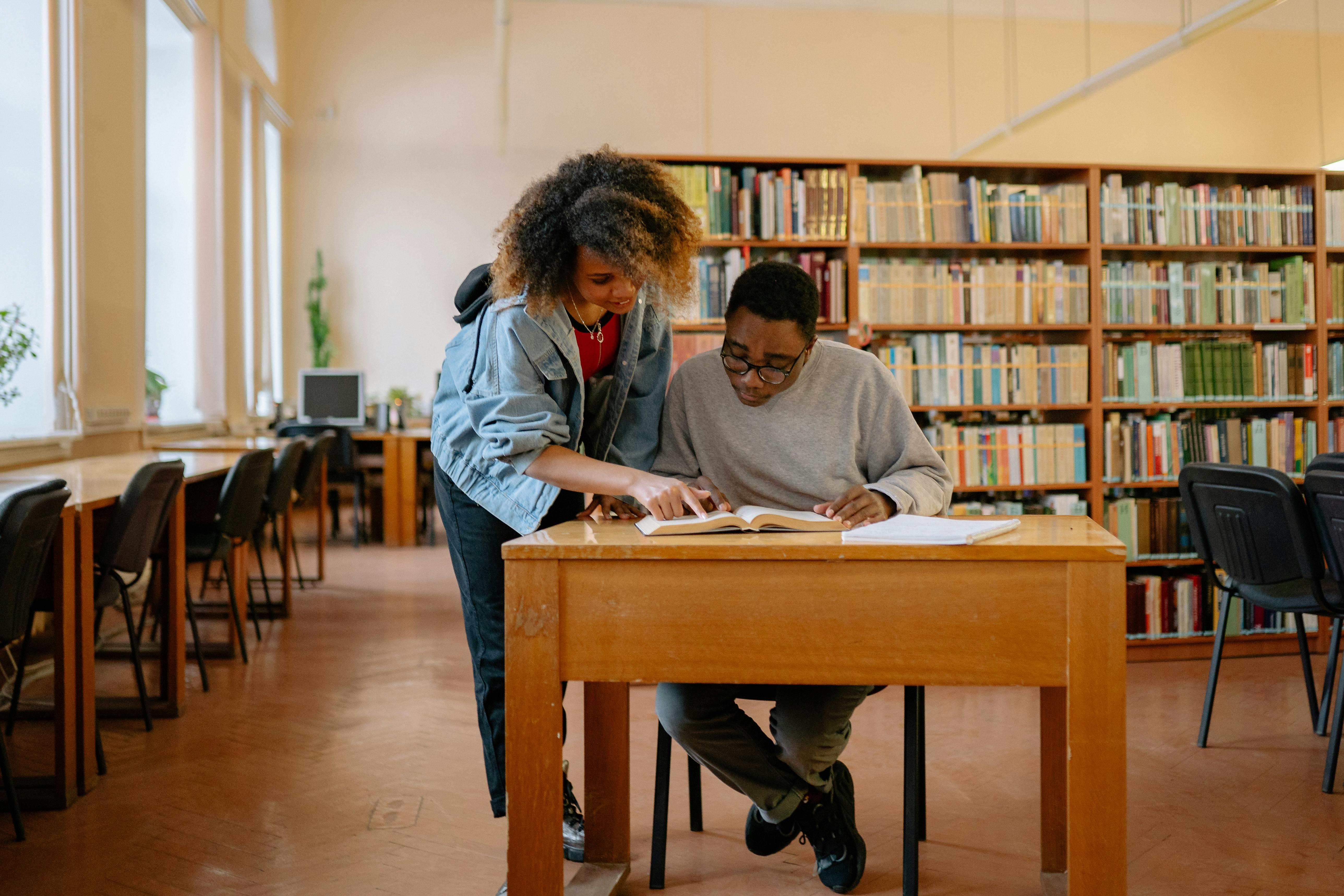 Man and Woman Reading a Book Inside the Library · Free Stock Photo