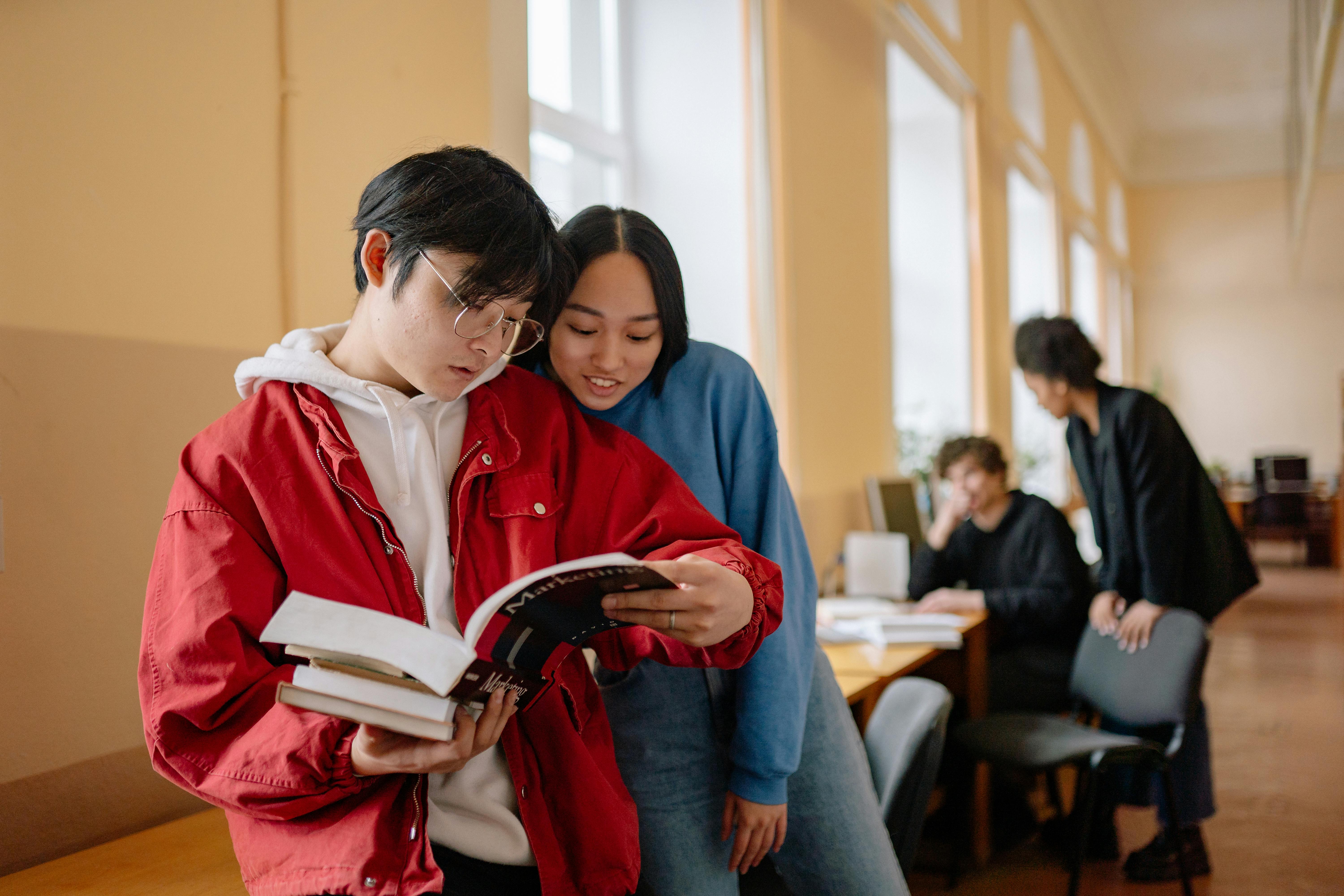 Girls Smiling Reading a Book · Free Stock Photo