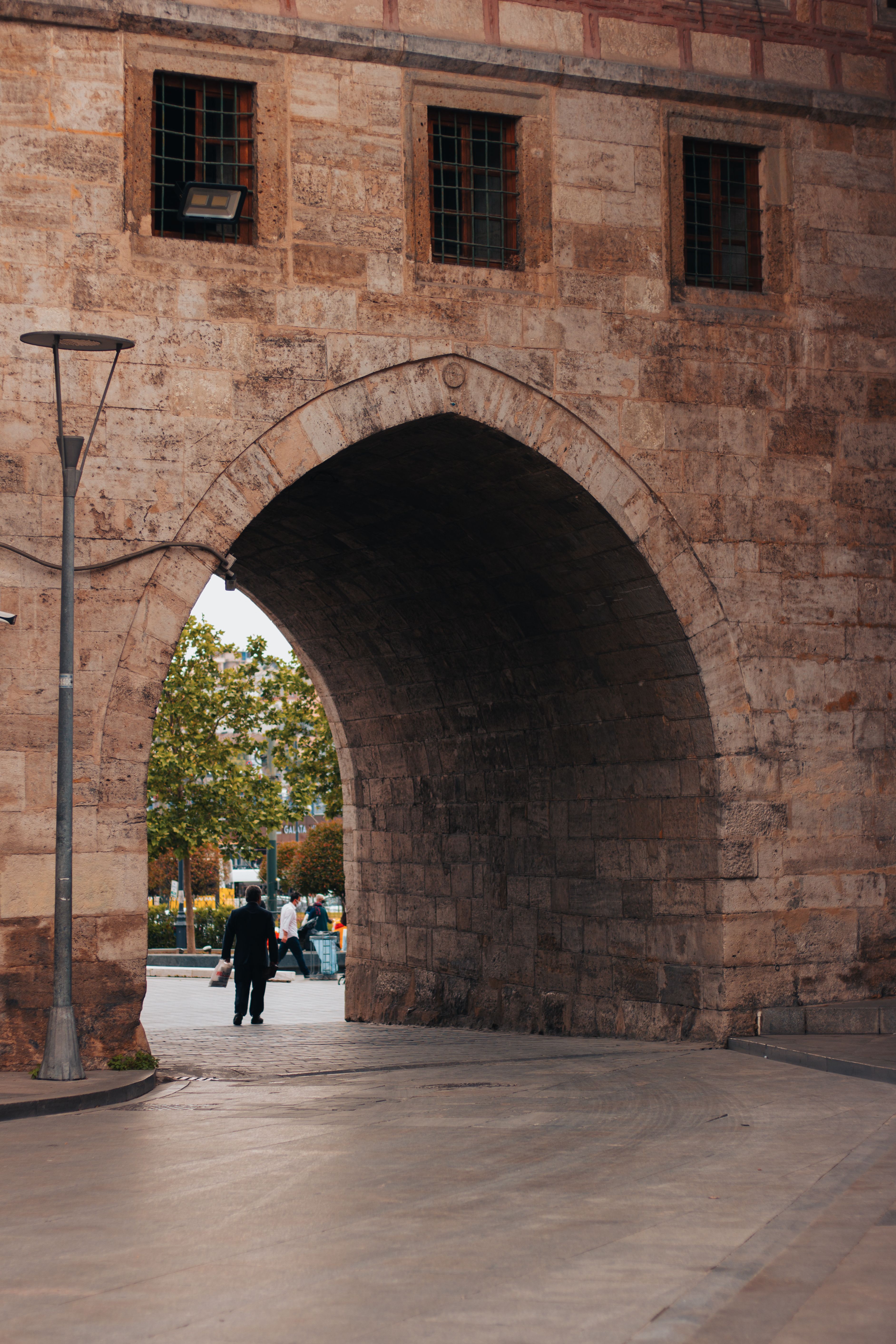 A Person Walking on an Arch of a Building · Free Stock Photo