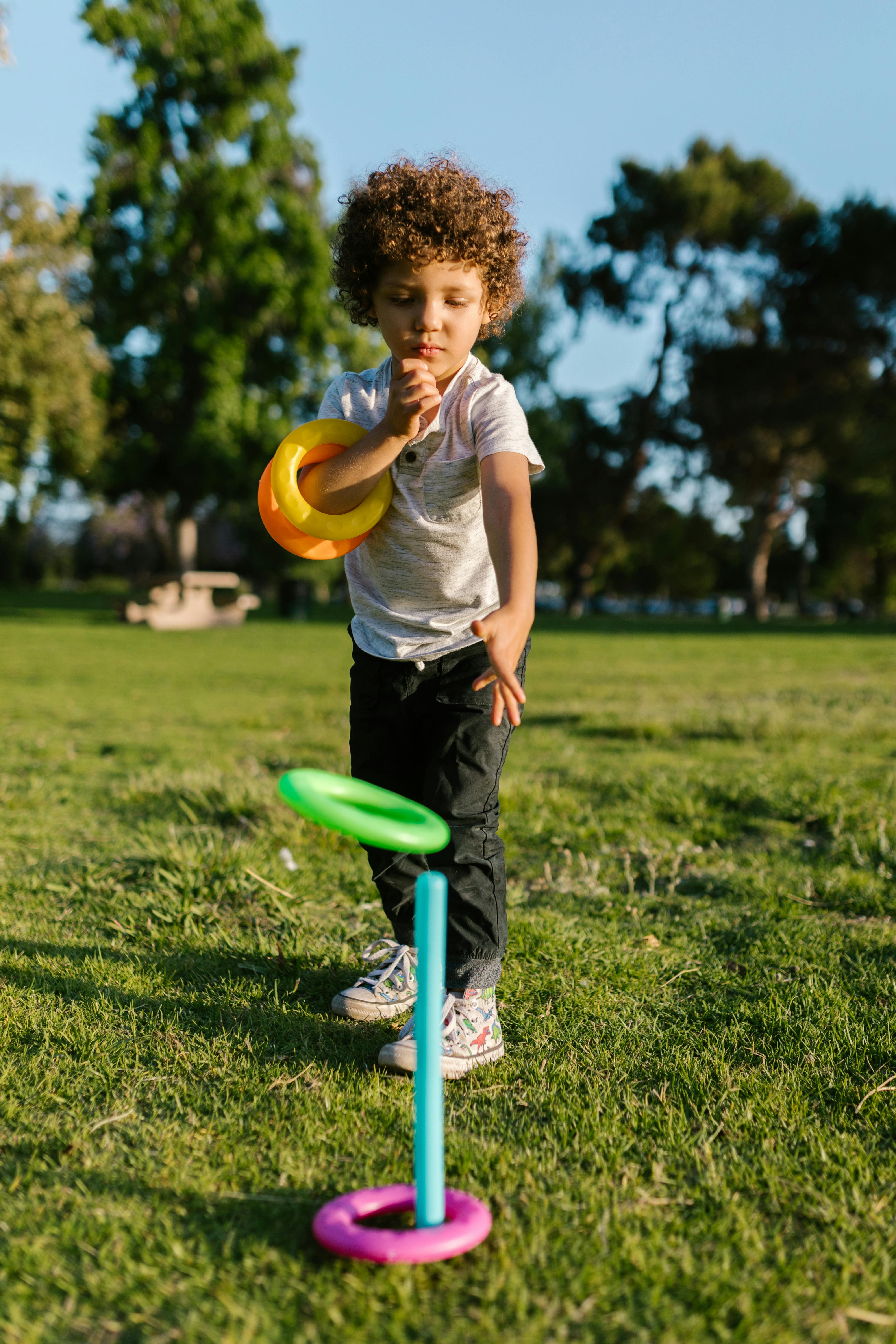 A Boy Playing Ring Toss in a Park · Free Stock Photo