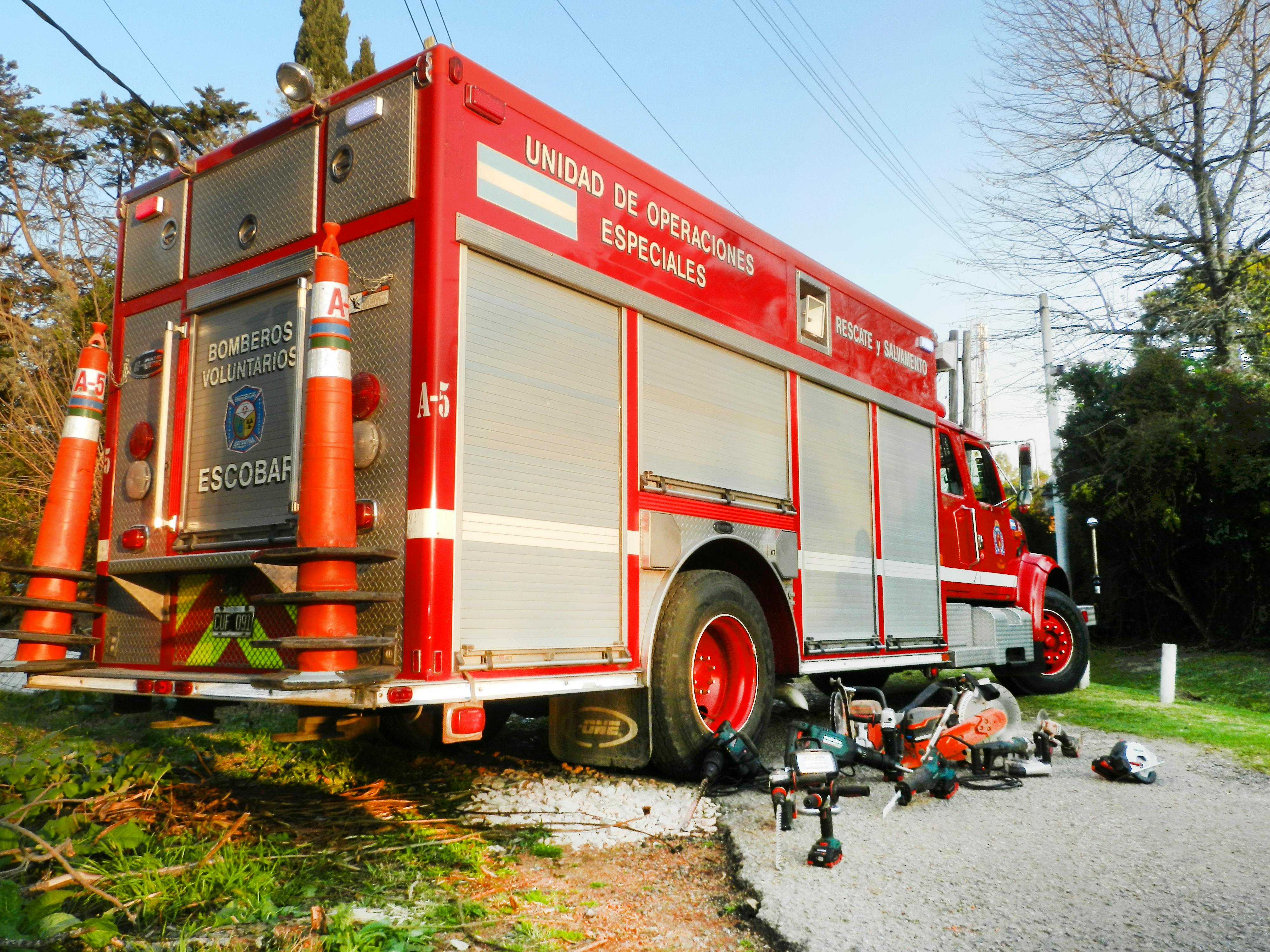 Fire engine truck driving along narrow busy street · Free Stock Photo