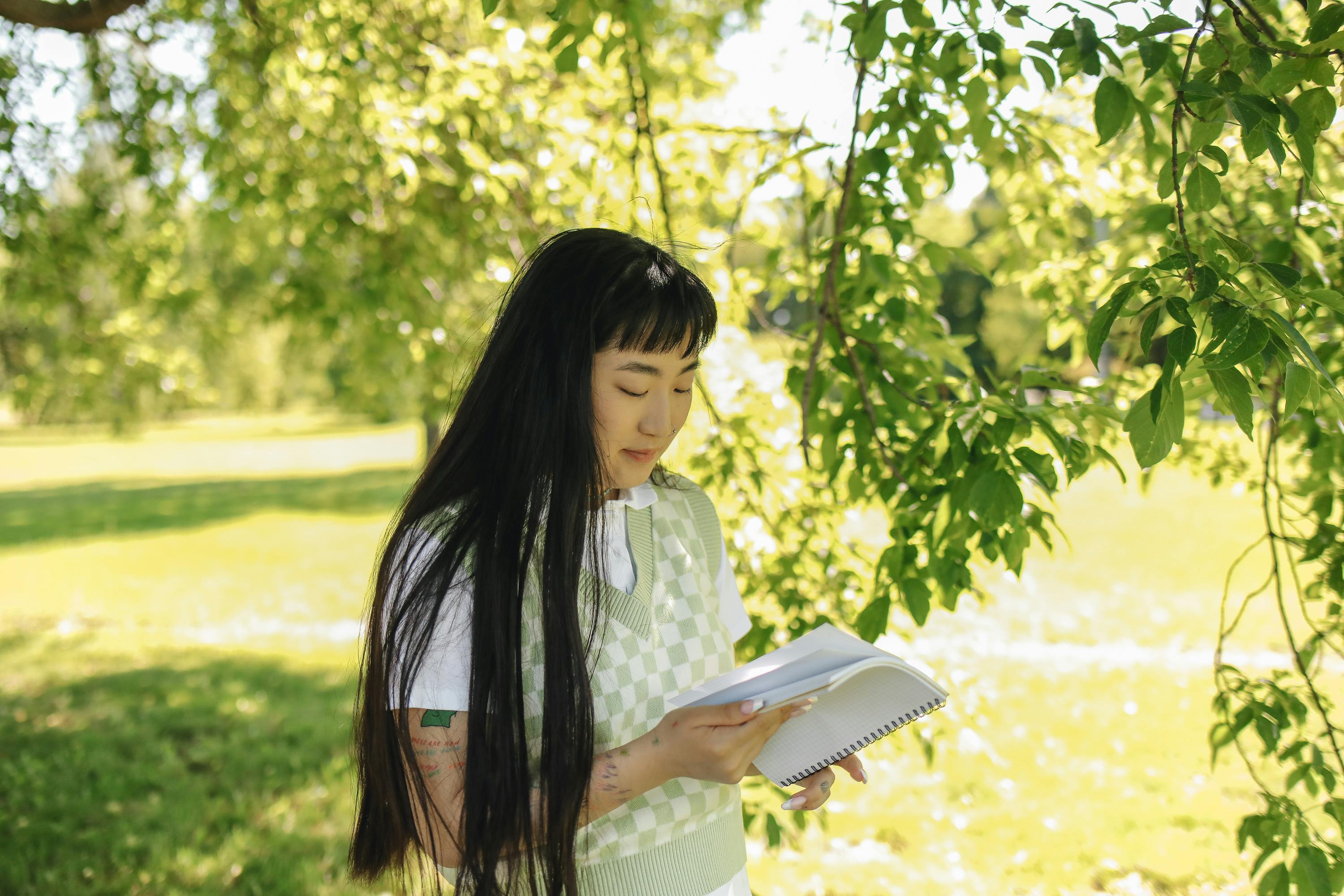 A Girl in White Dress Reading a Notebook · Free Stock Photo