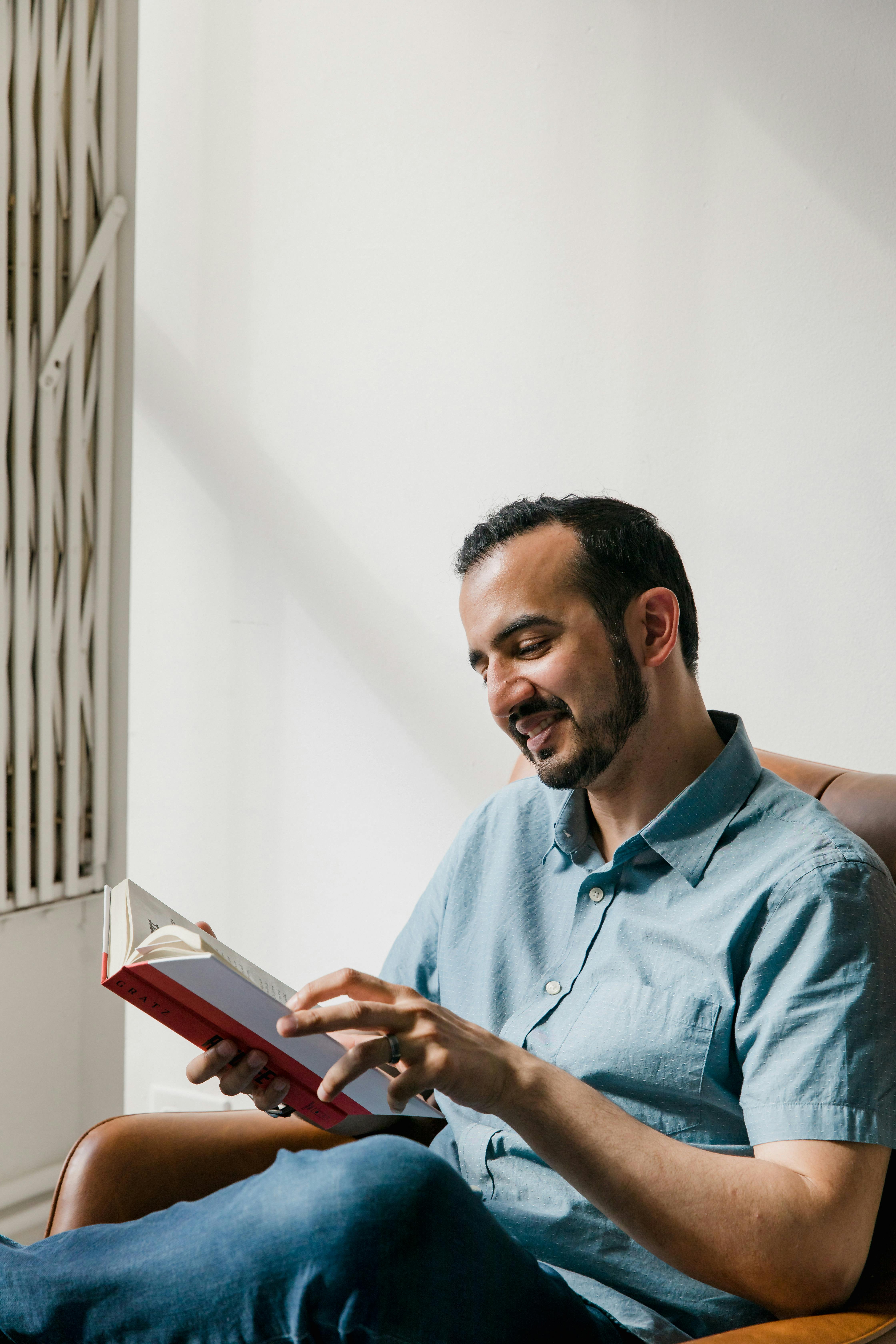 Man in Blue Dress Shirt Reading a Book · Free Stock Photo