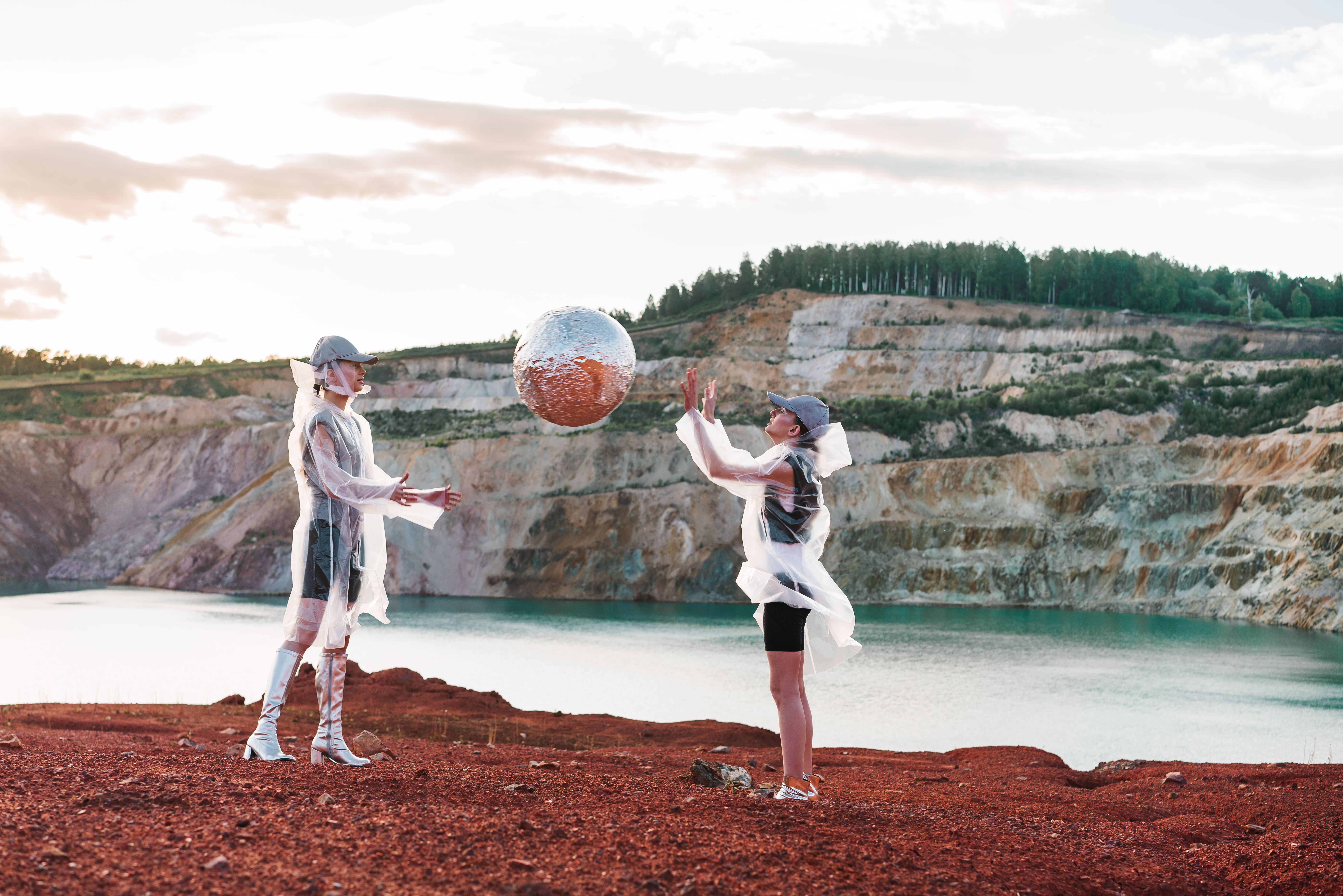 Women in Transparent Raincoats Throwing a Ball Covered with Foil · Free ...