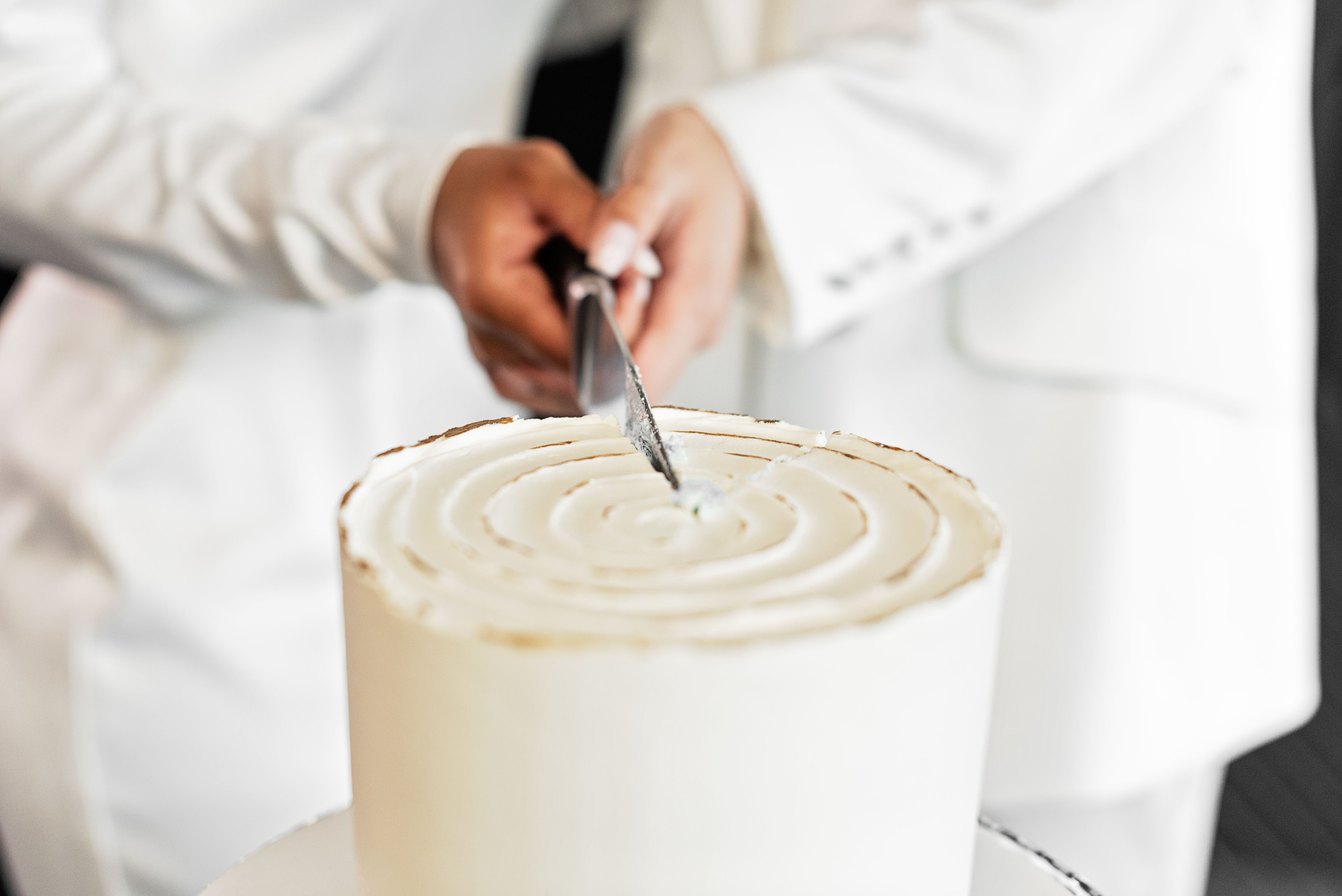 A Knife Slicing Through a Wedding Cake · Free Stock Photo