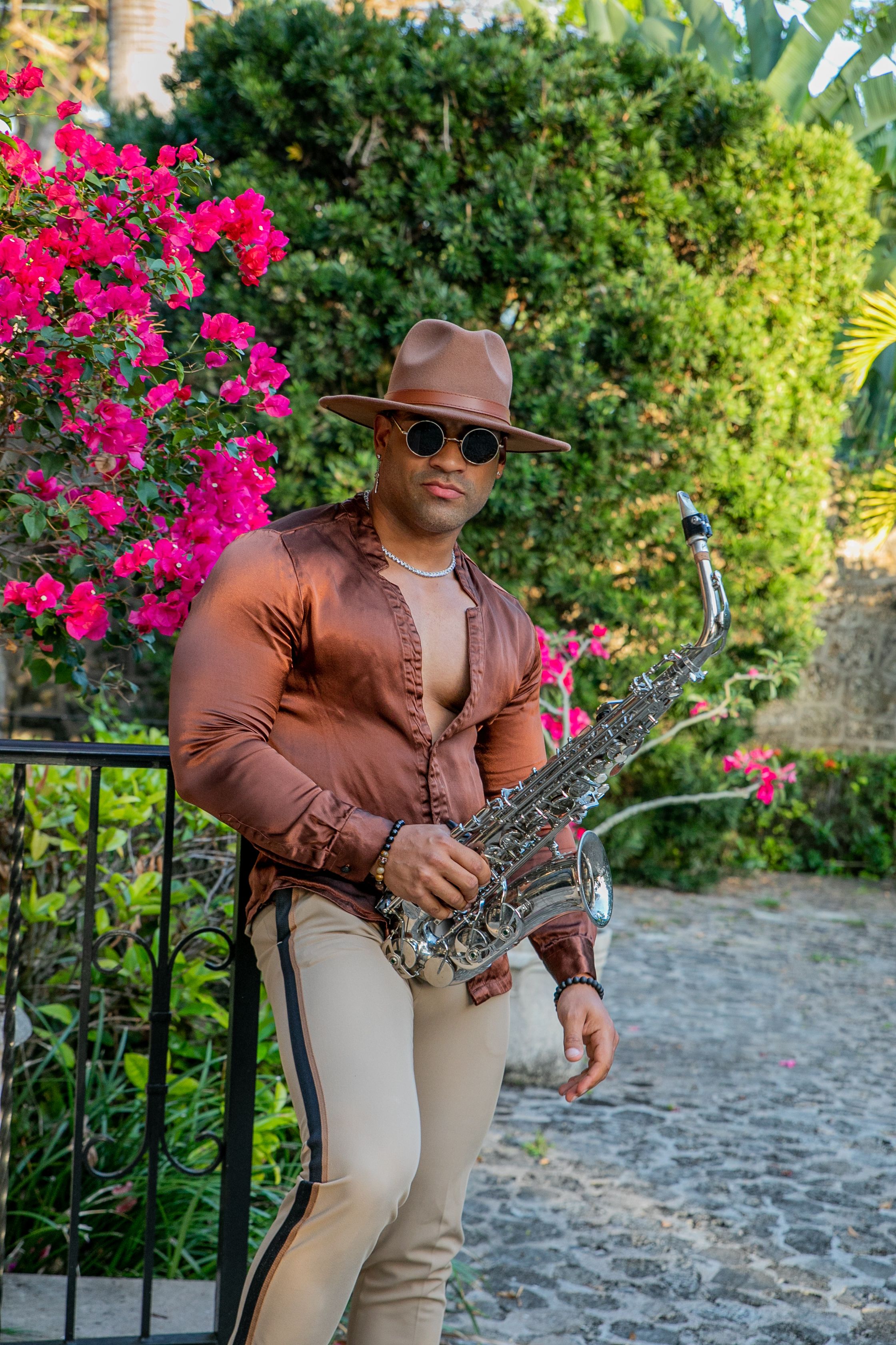 Muscular Saxophonist in a Hat and a Satin Shirt Posing in the Garden ...