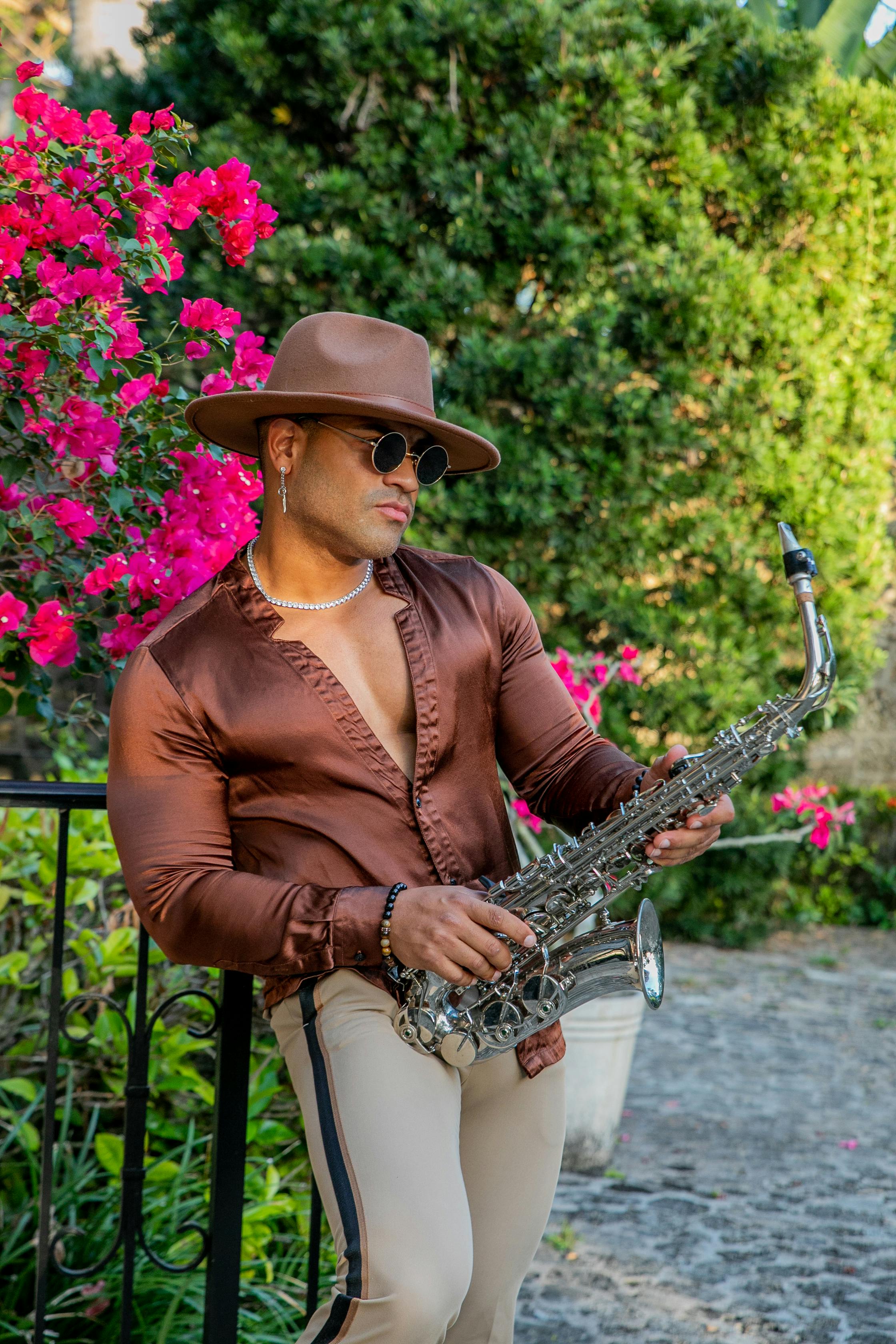 Man Sitting on Stool While Playing Saxophone Beside Fence · Free Stock ...