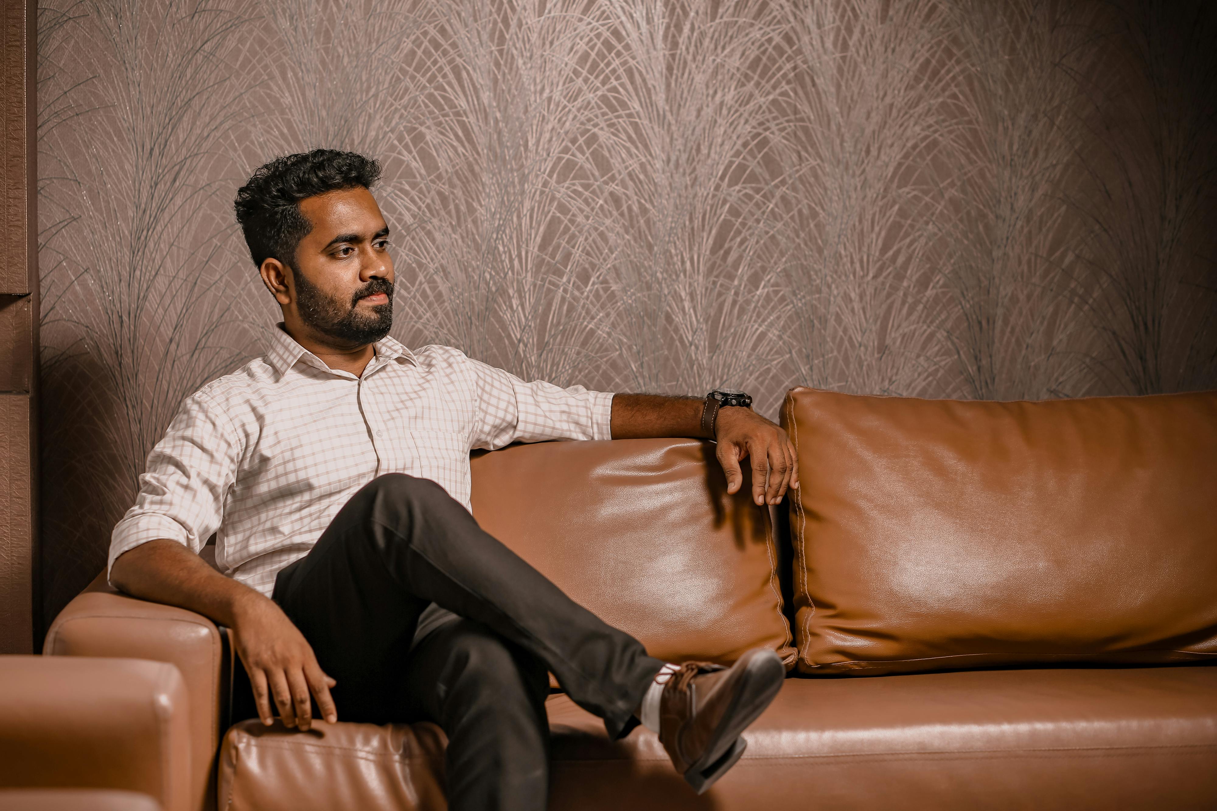 A Man Sitting on a Leather Couch · Free Stock Photo