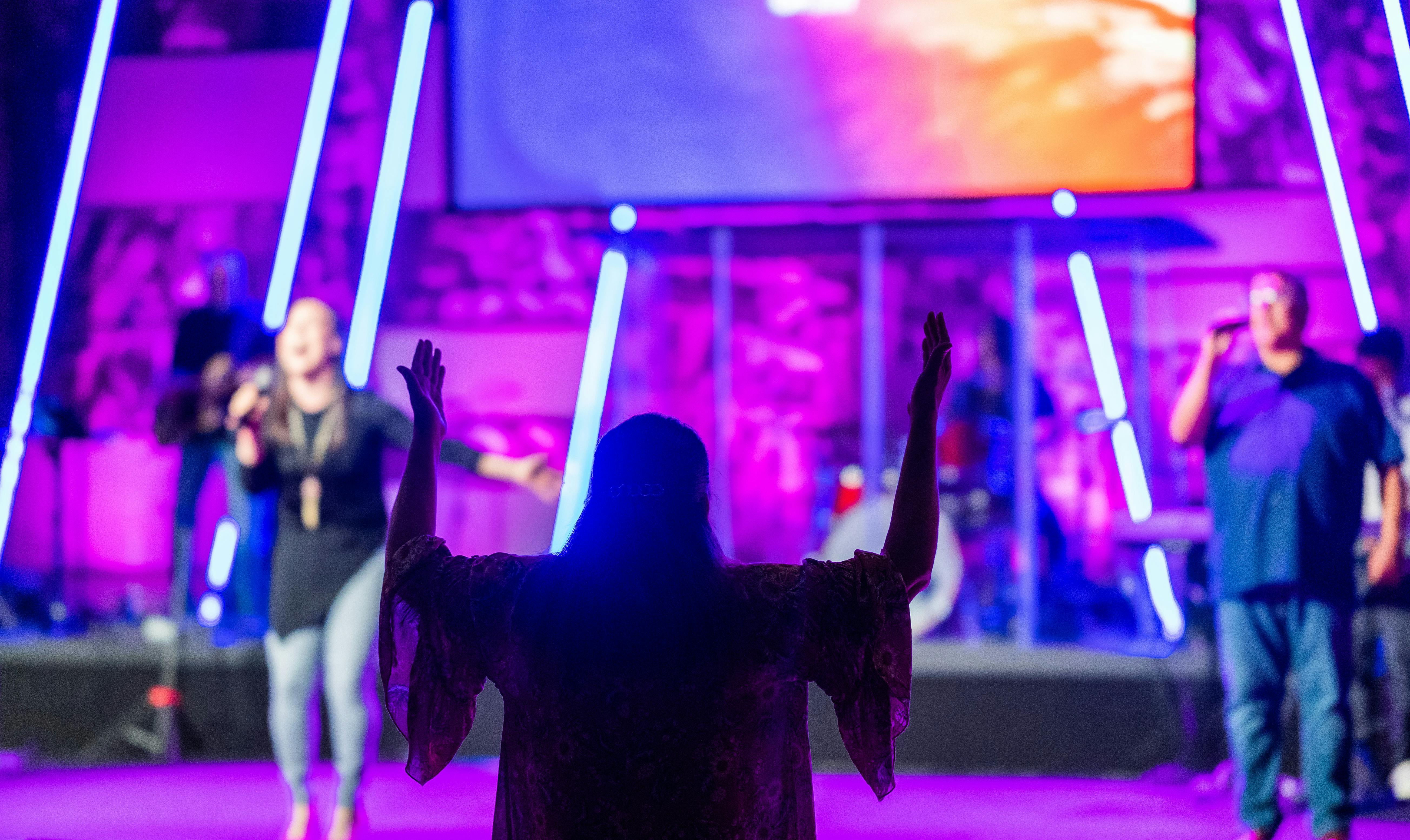 Woman Standing in Front of a Stage and People Performing · Free Stock Photo