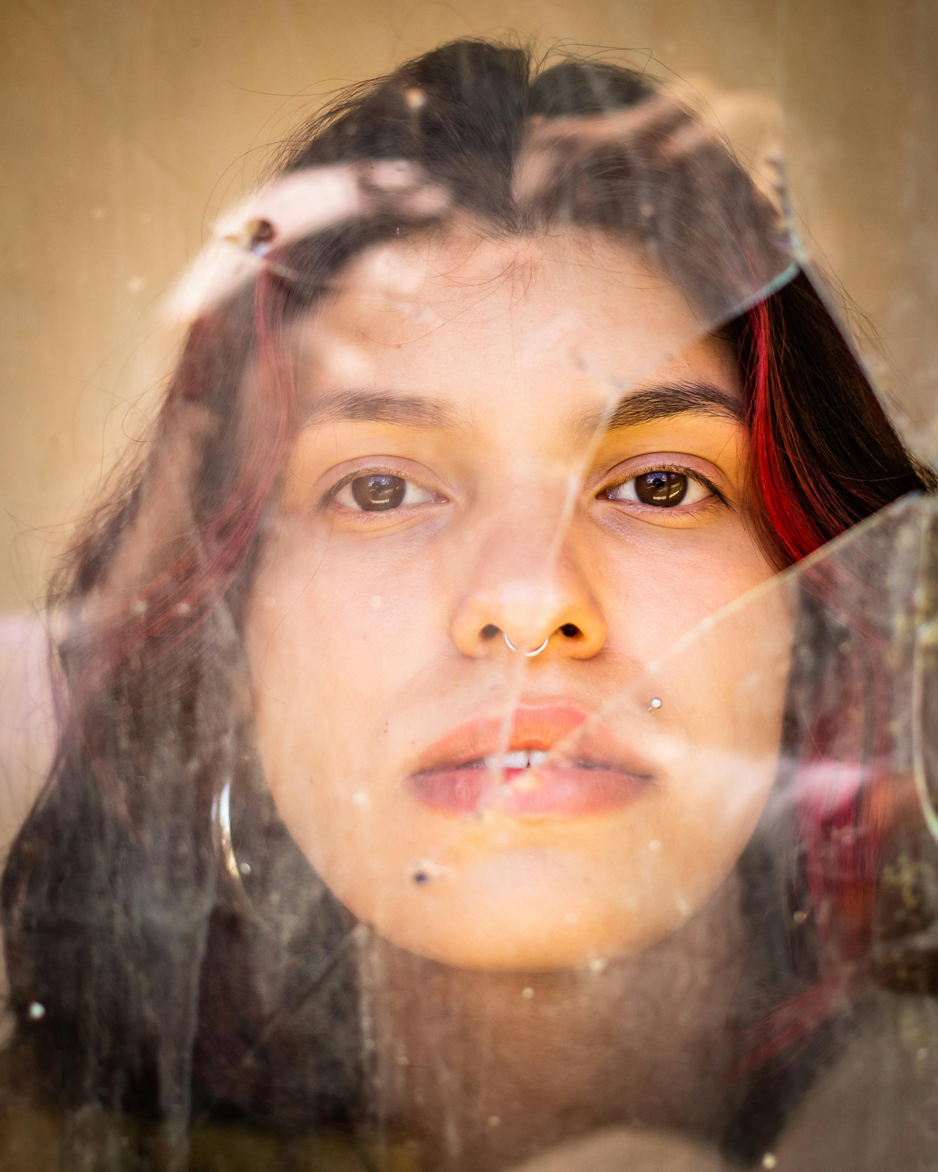 Portrait of a Young Woman Behind a Broken Window · Free Stock Photo