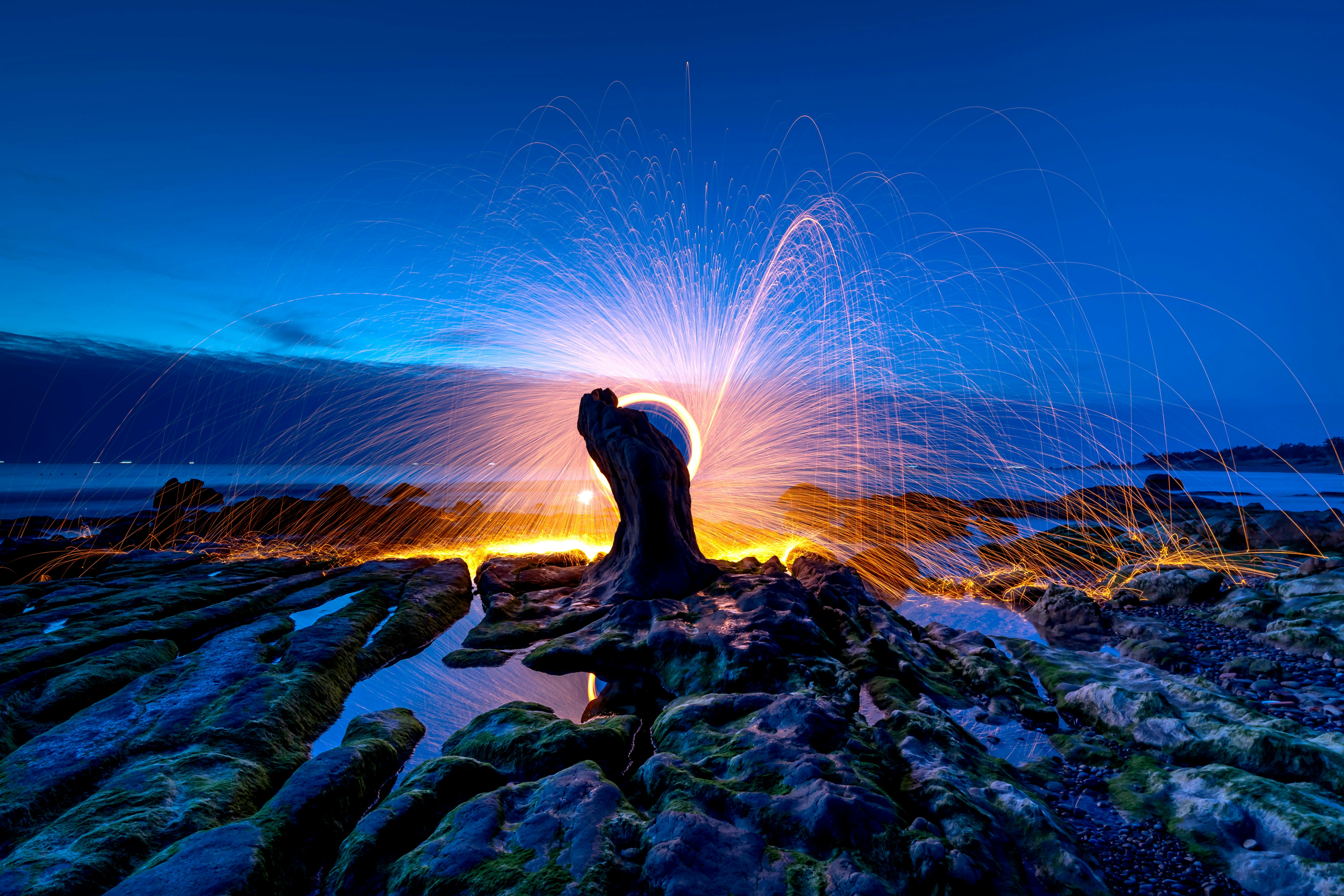 Sparks over Rocks on Seashore · Free Stock Photo