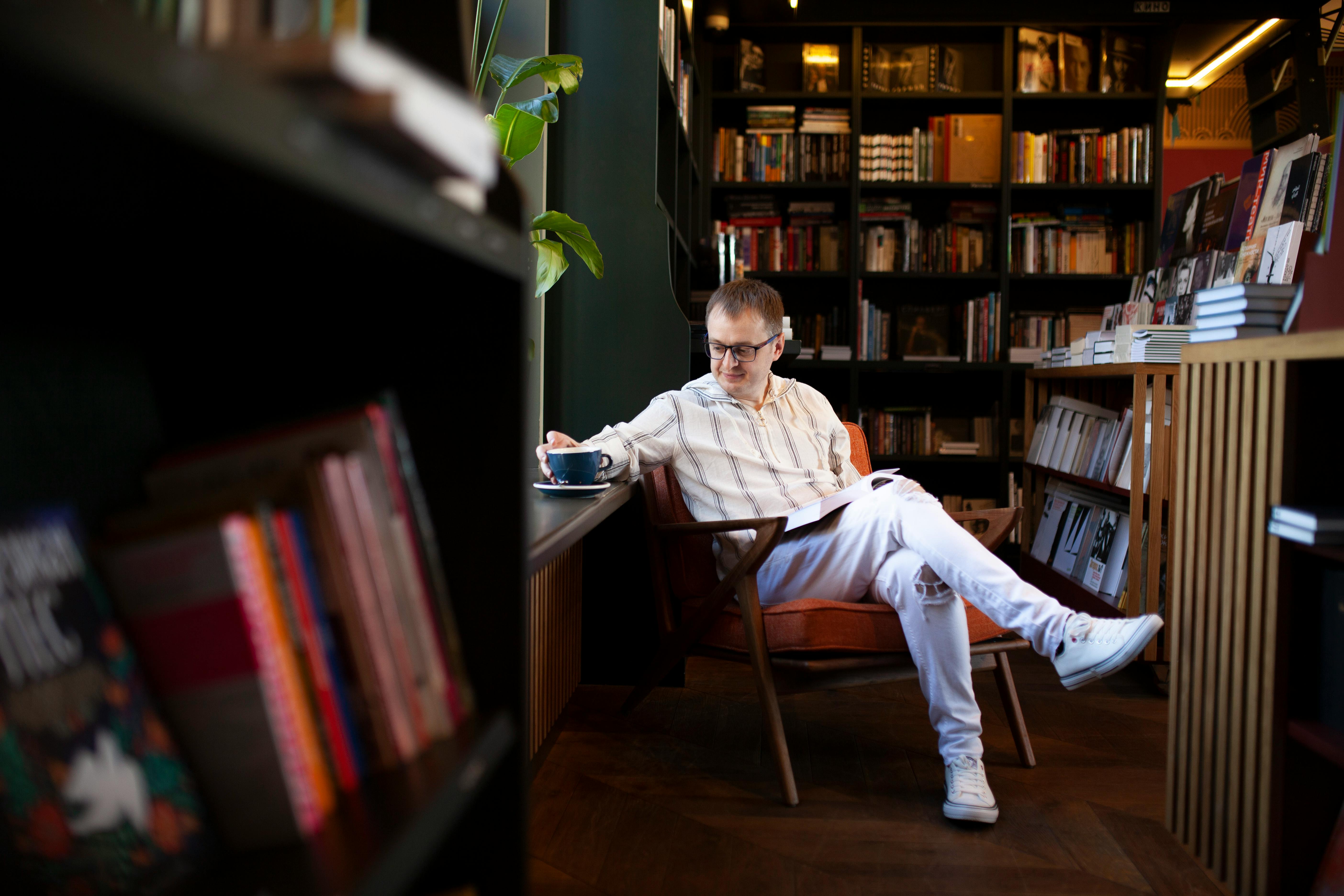 Man Sitting on a Chair Inside a Library · Free Stock Photo