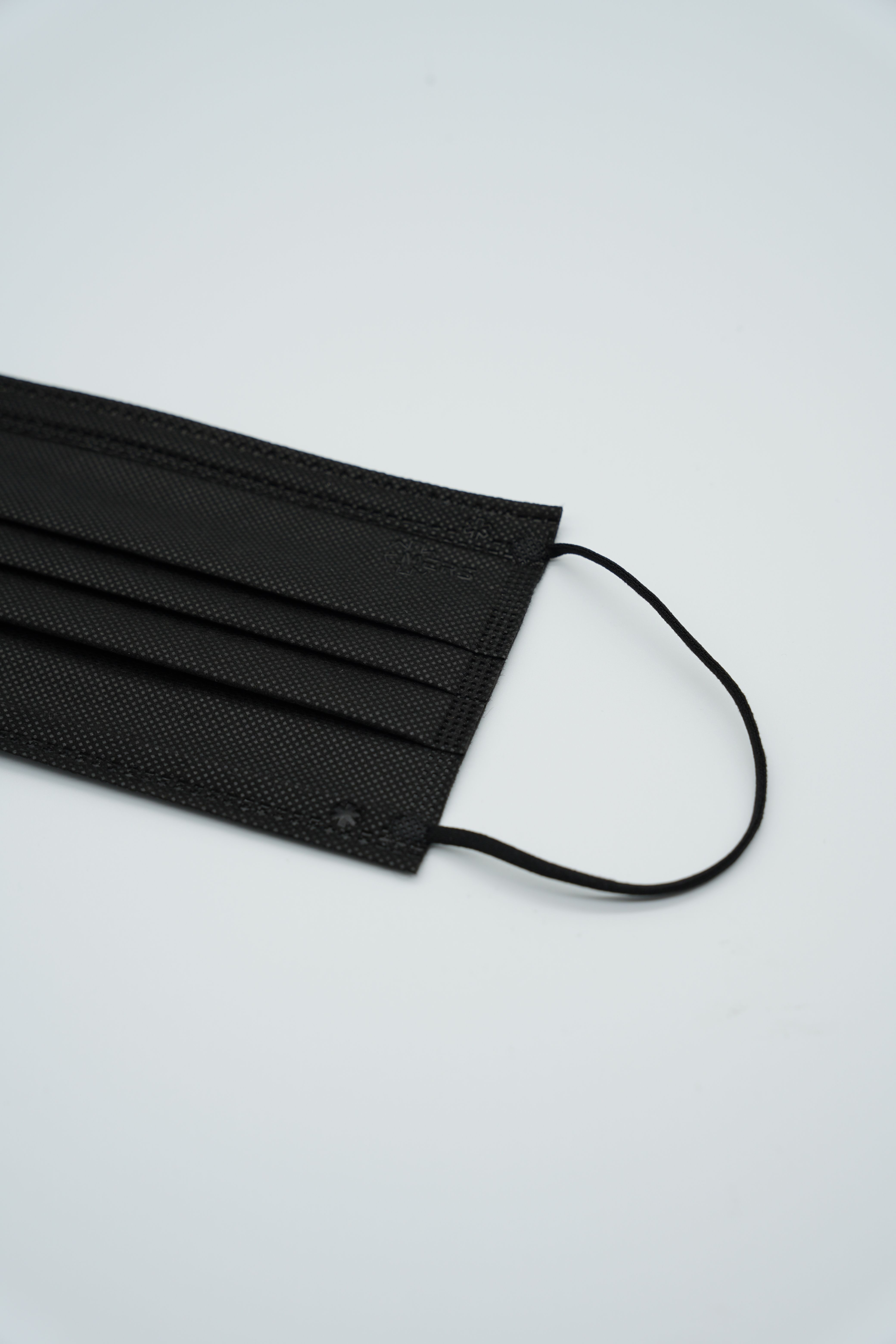Black Face Mask on a White Surface · Free Stock Photo
