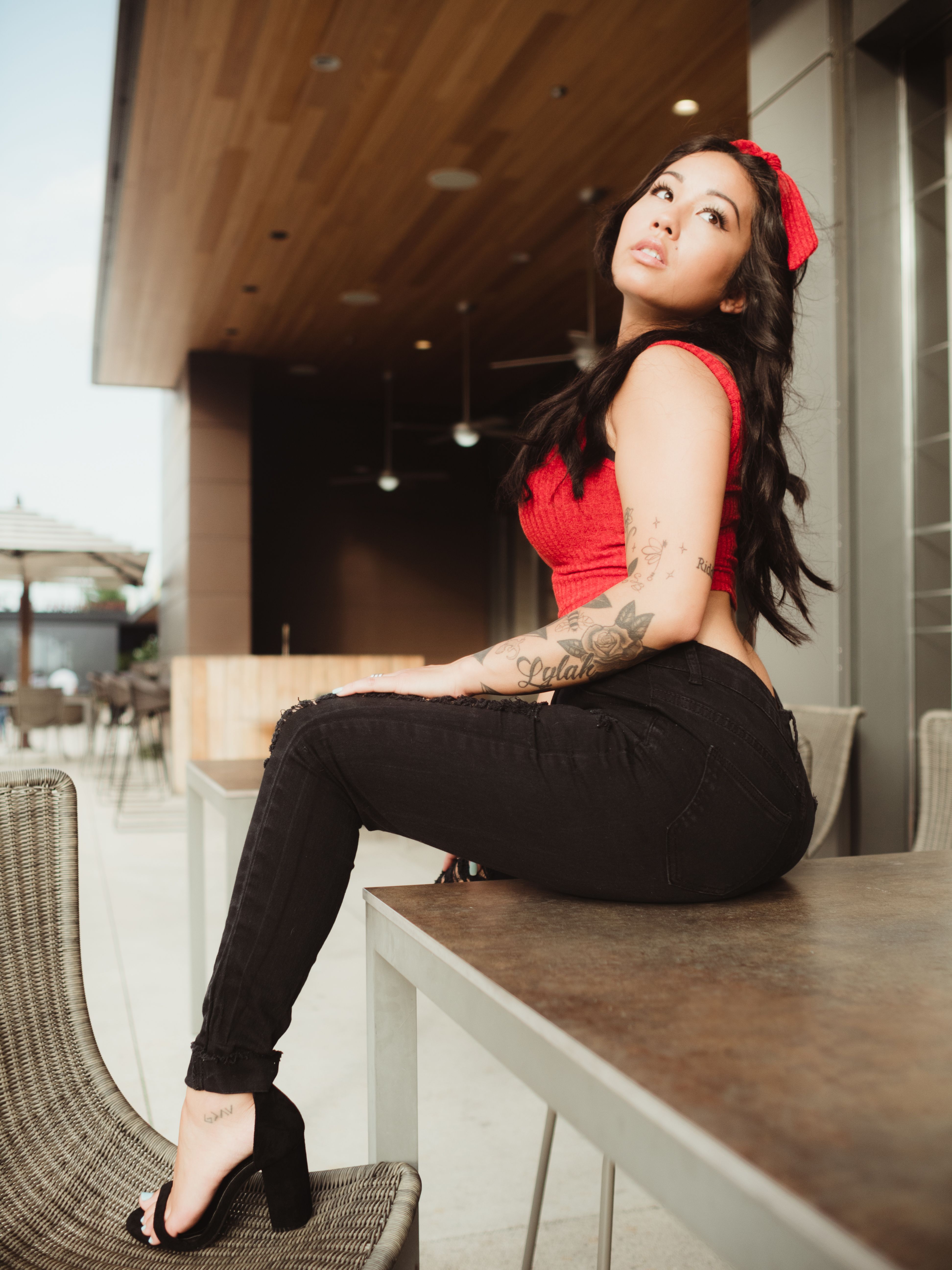 Beautiful Woman with an Arm Tattoo Sitting while Looking Away · Free ...