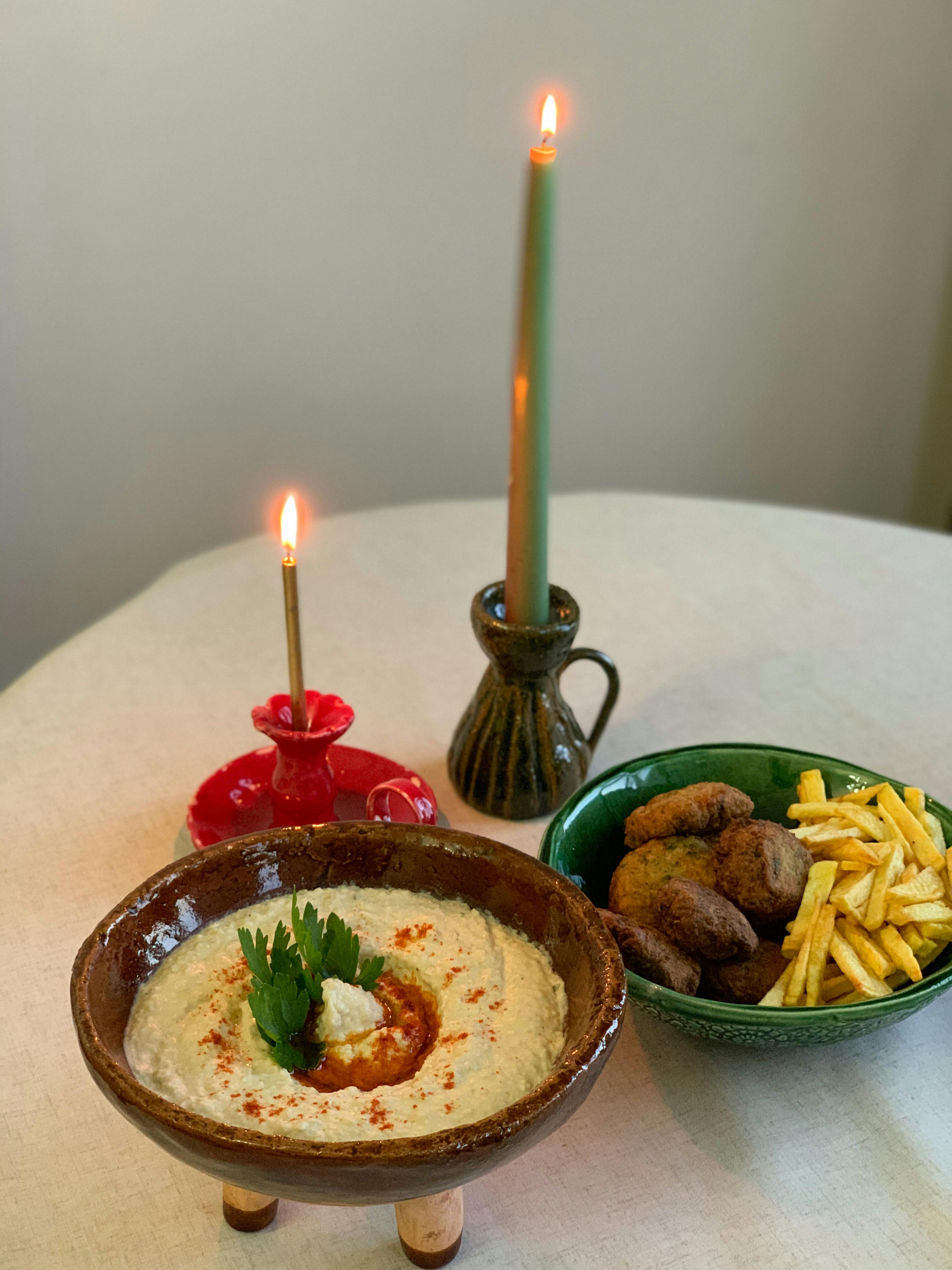 Vegetable spread and meatballs with French fries near burning candles ...