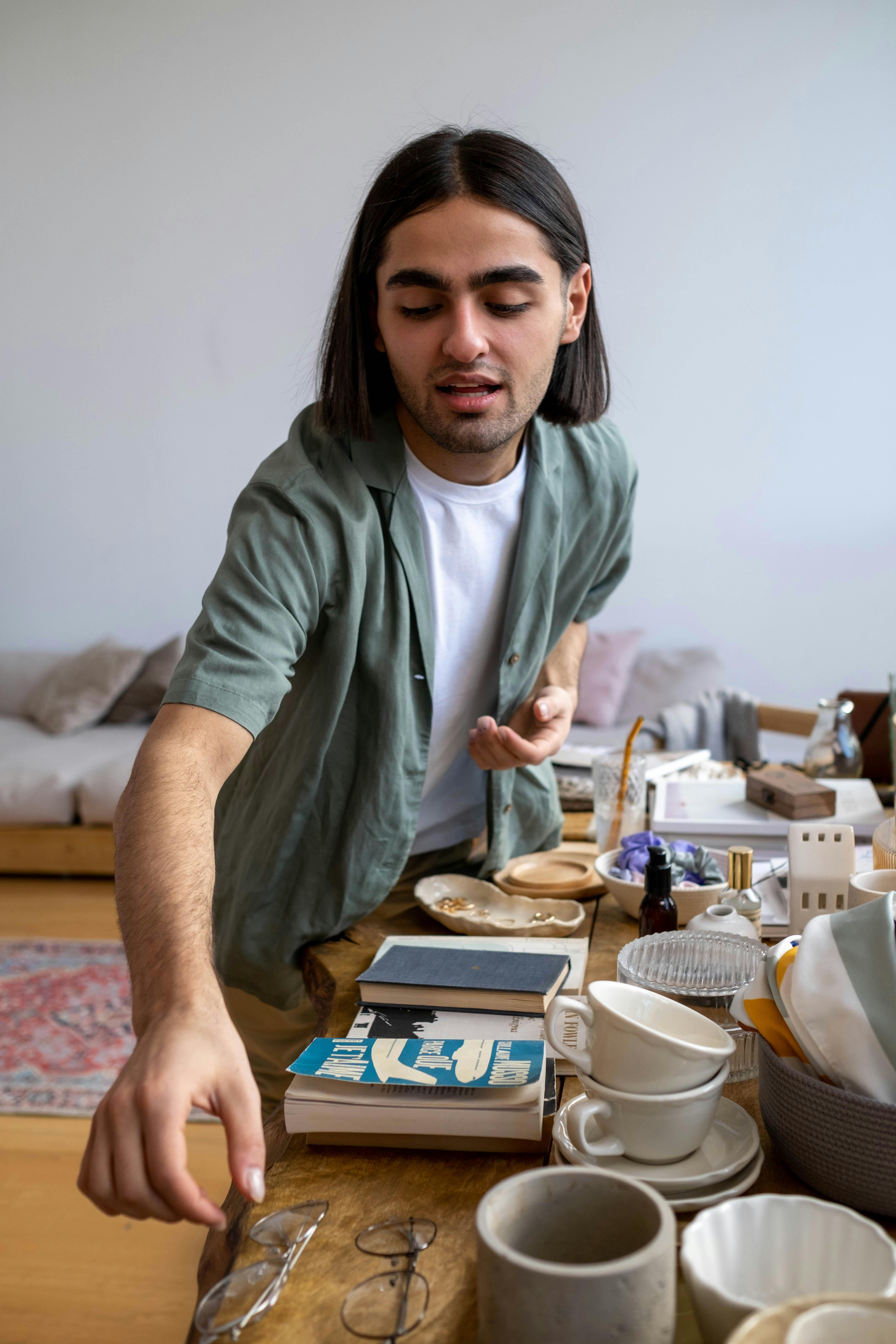 Man Bending over Table with Cups and Books · Free Stock Photo