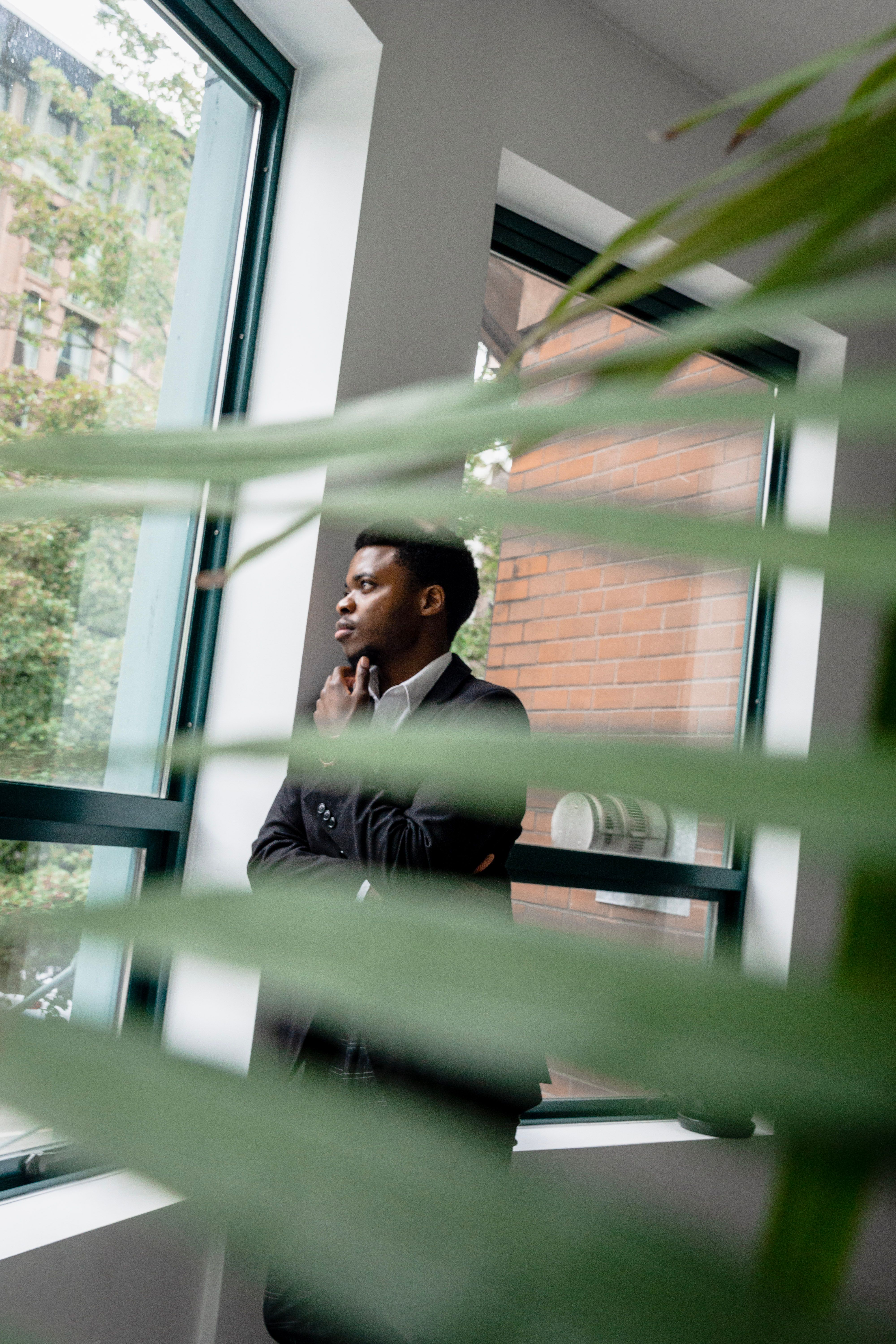 Man Standing Beside Glass Window · Free Stock Photo