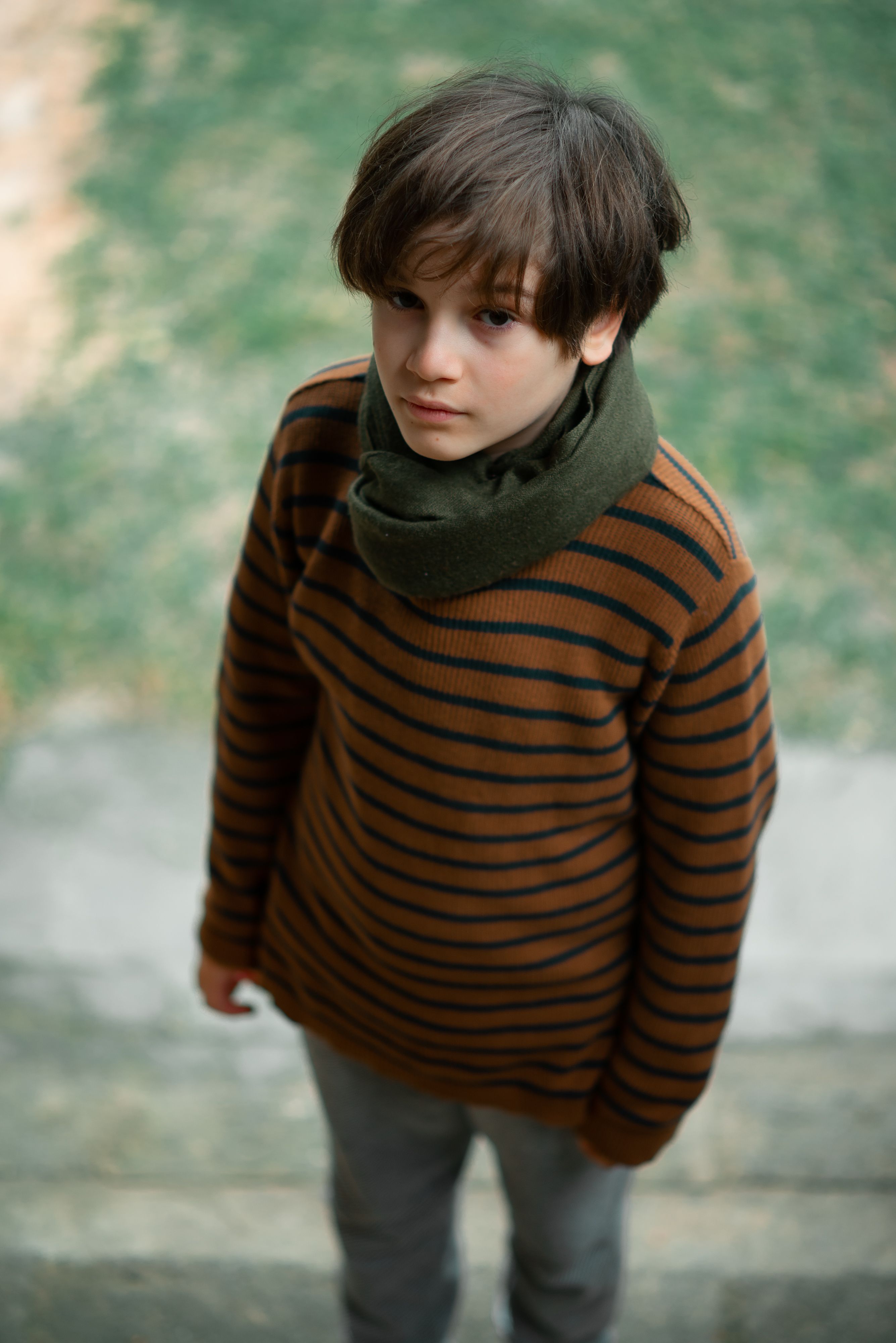 A Young Boy in Denim Jeans Sitting Near the White Wall · Free Stock Photo