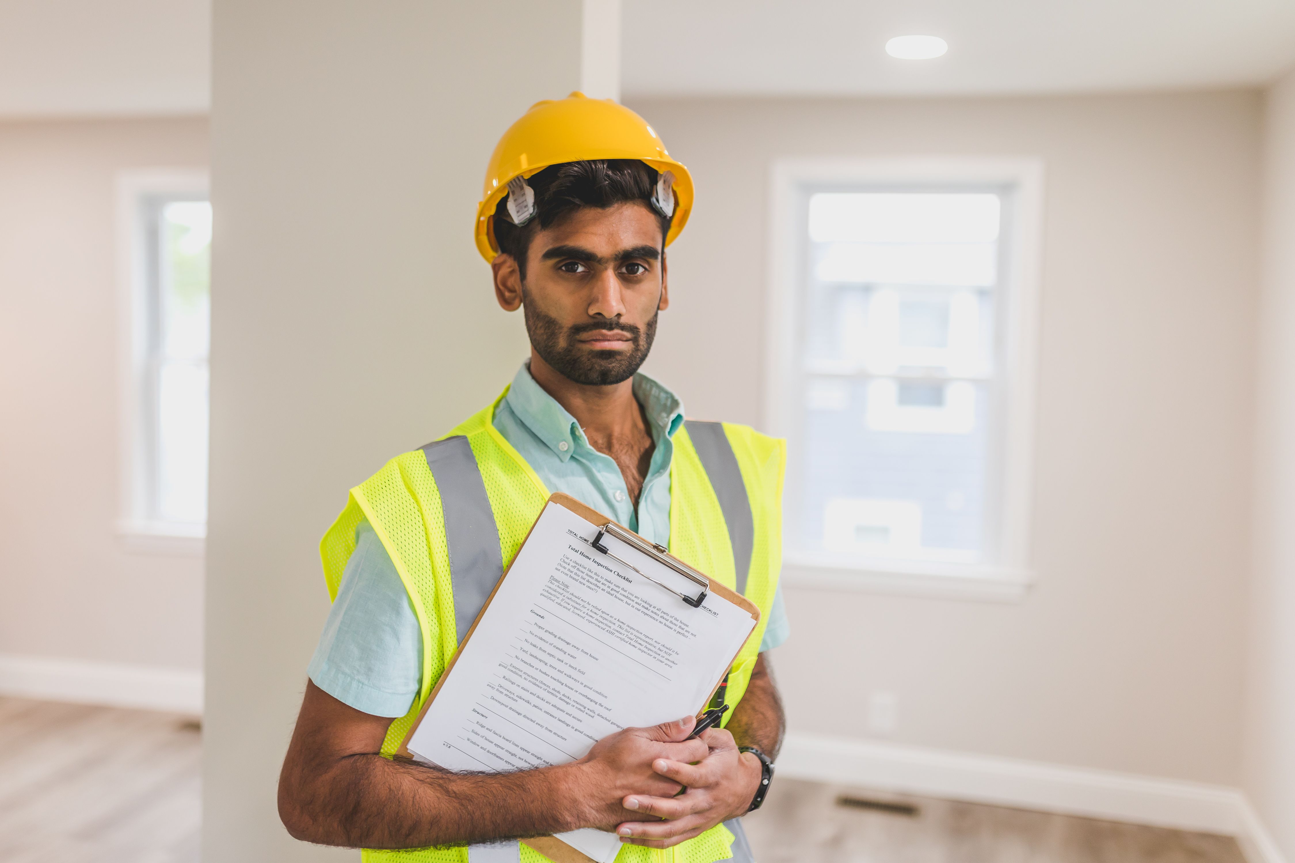 A Man in Safety Vest and Hard Hat Checking the Front Door · Free Stock ...