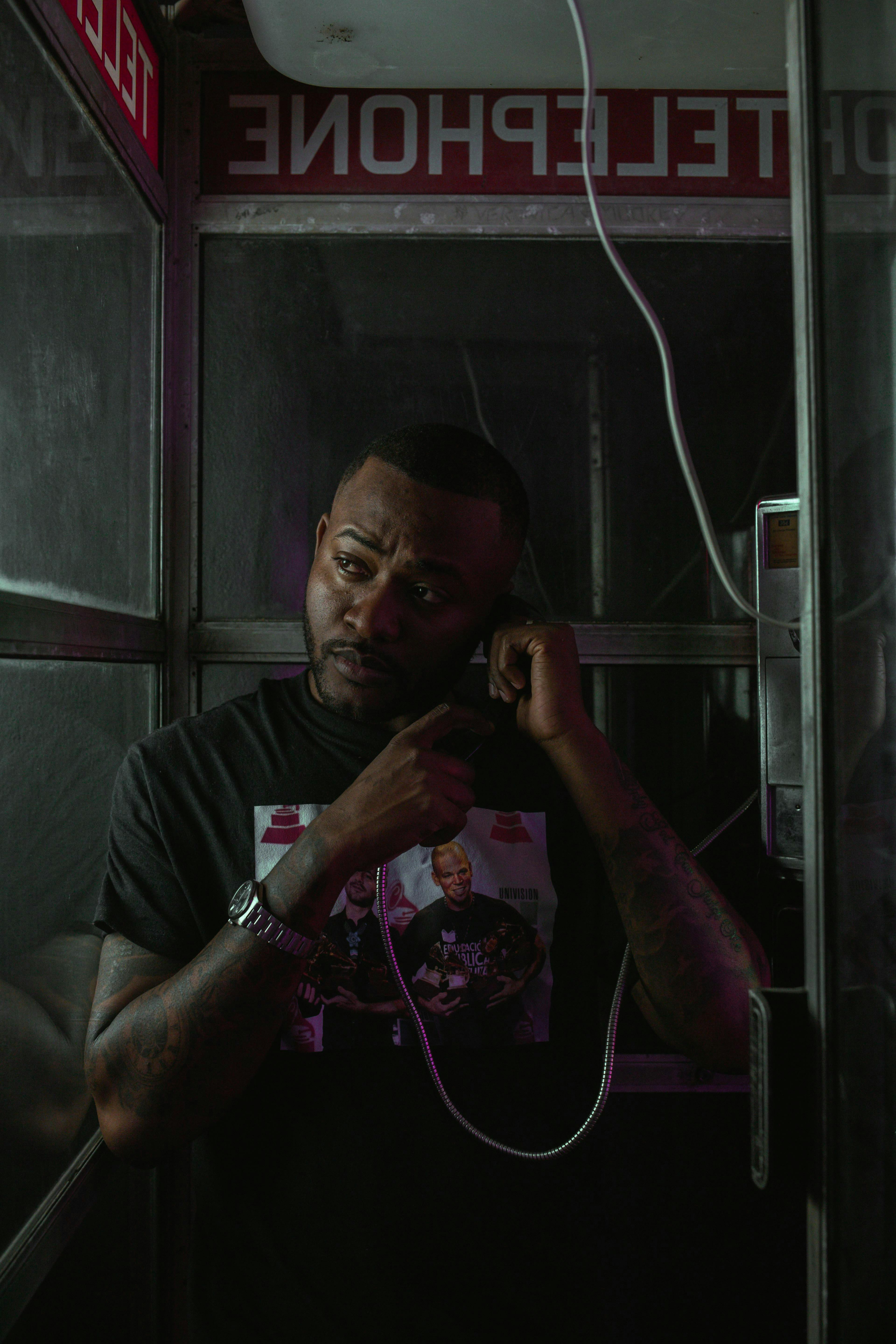 Man Standing Inside a Telephone Booth · Free Stock Photo
