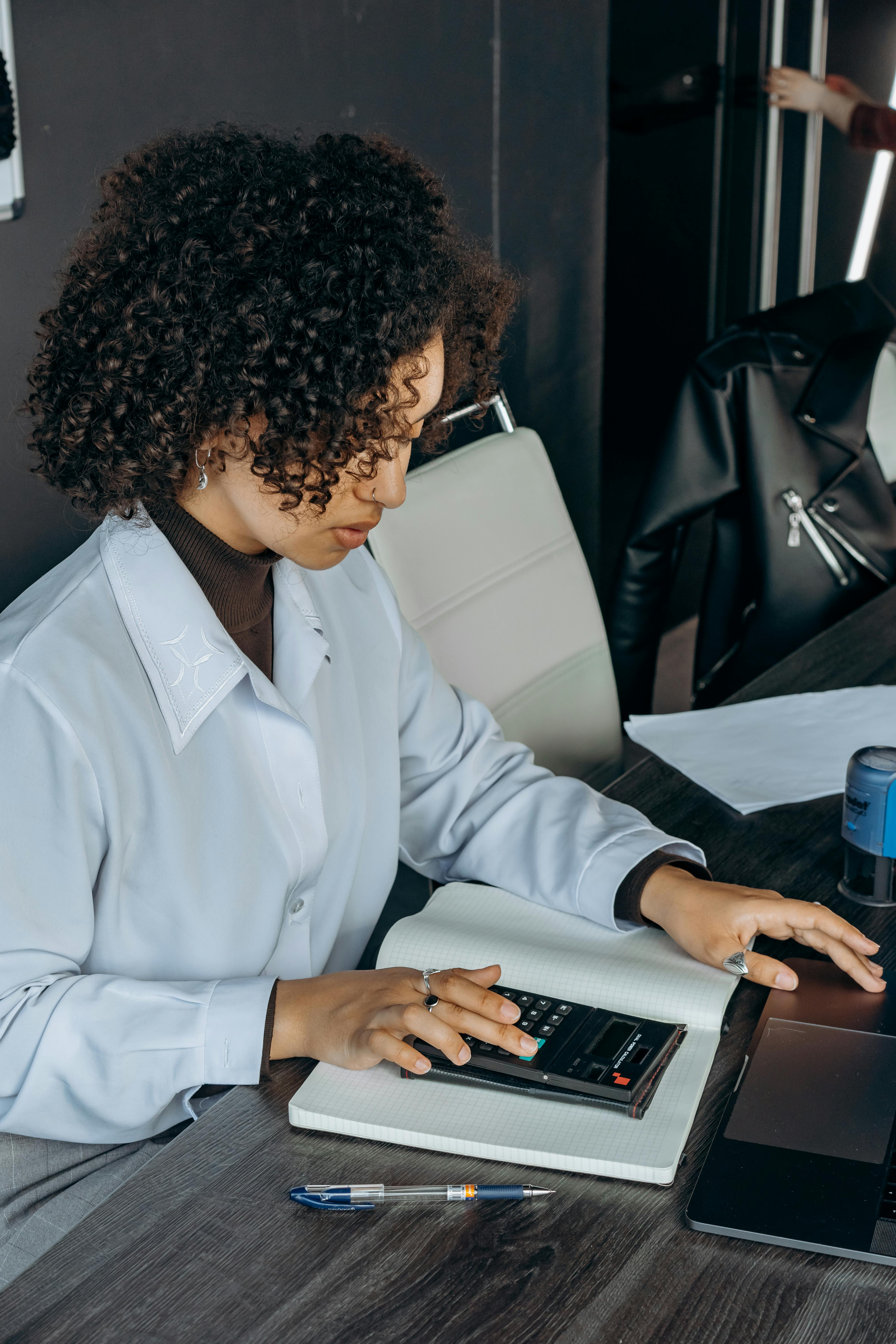 A Woman Using a Calculator · Free Stock Photo
