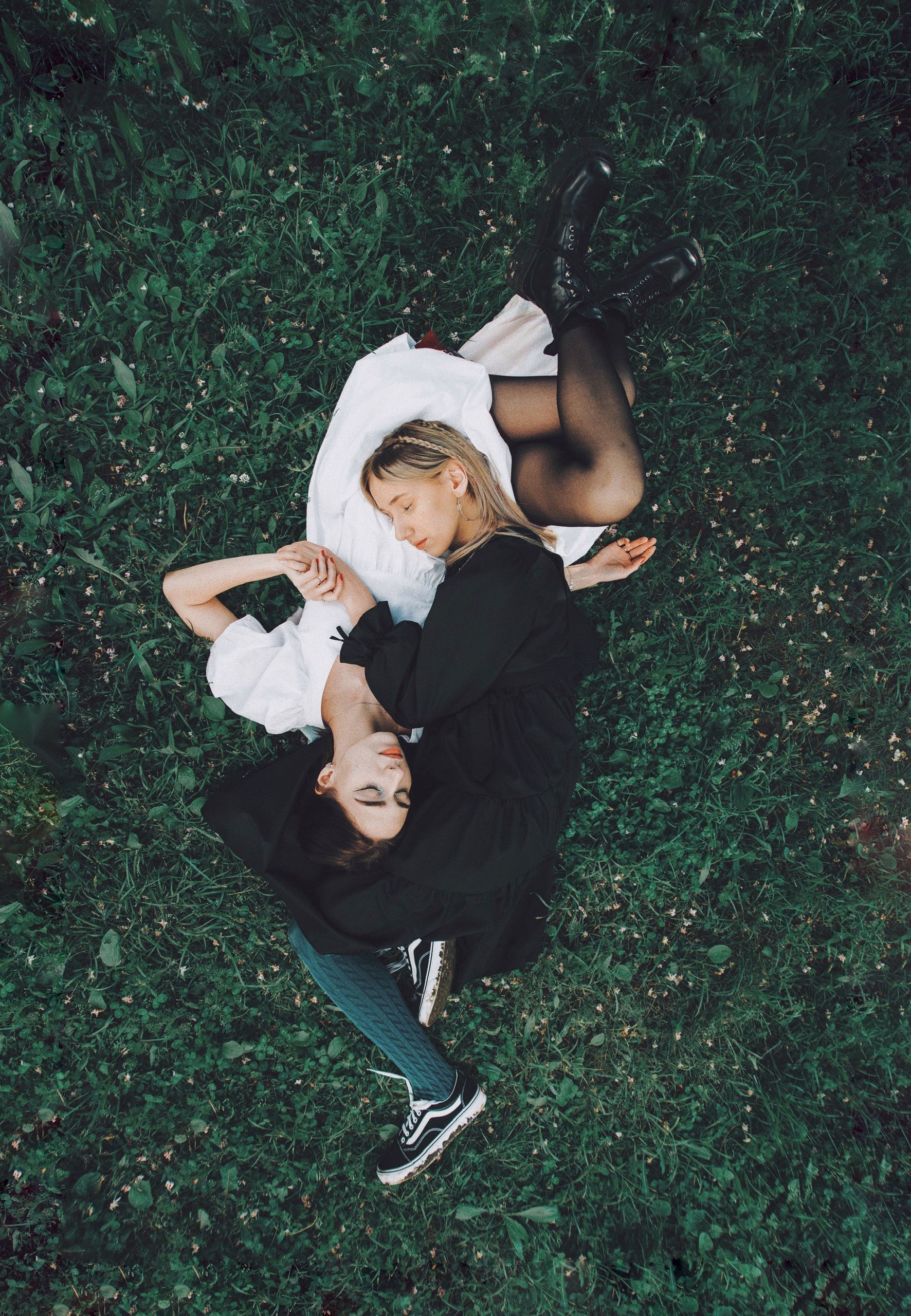 Top View of Women Lying In Opposite Directions on Grass and Hugging ...