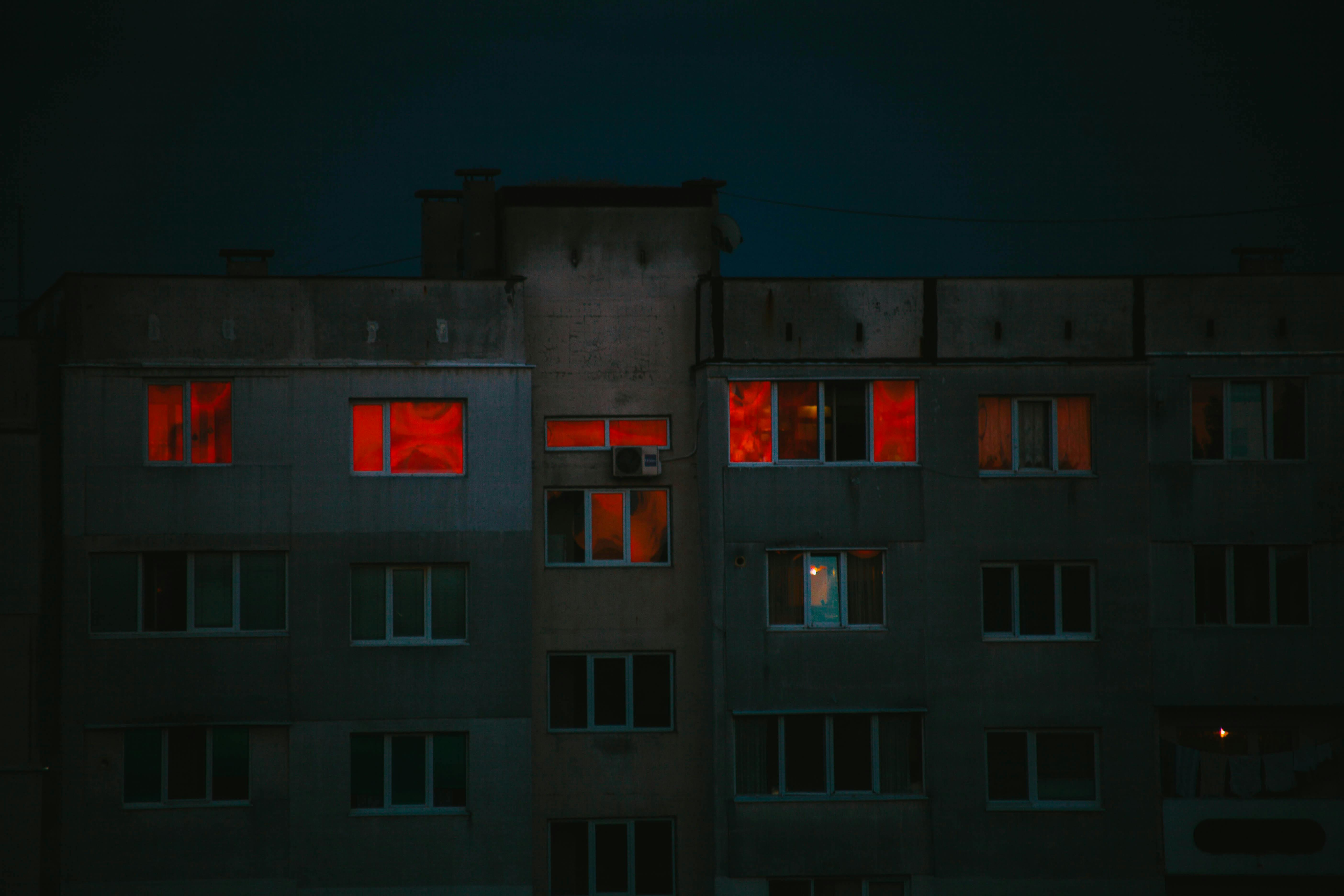 Red Lights on the Windows of an Apartment Building · Free Stock Photo
