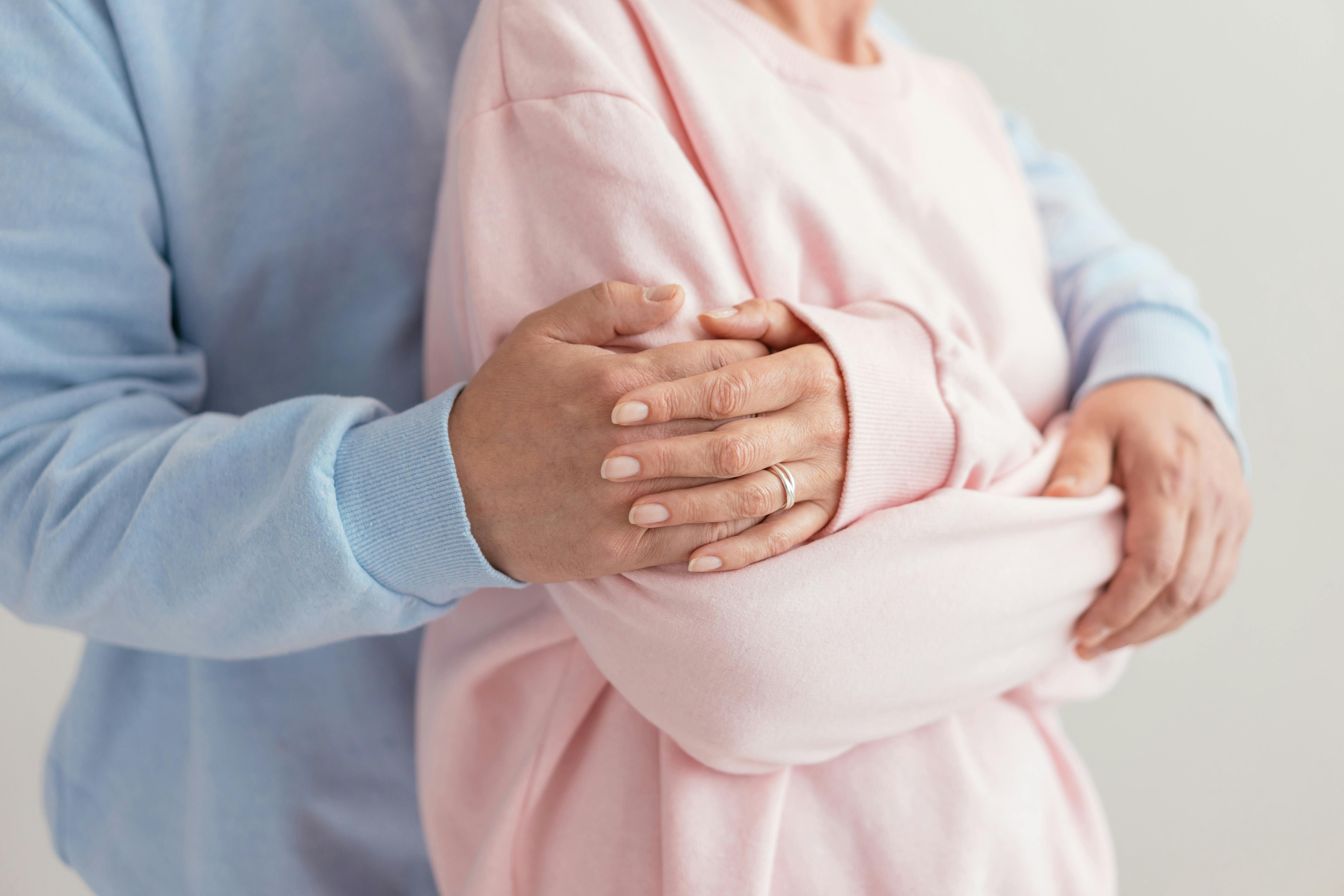 A Person in Blue Jacket Hugging a Person in Pink Jacket · Free Stock Photo