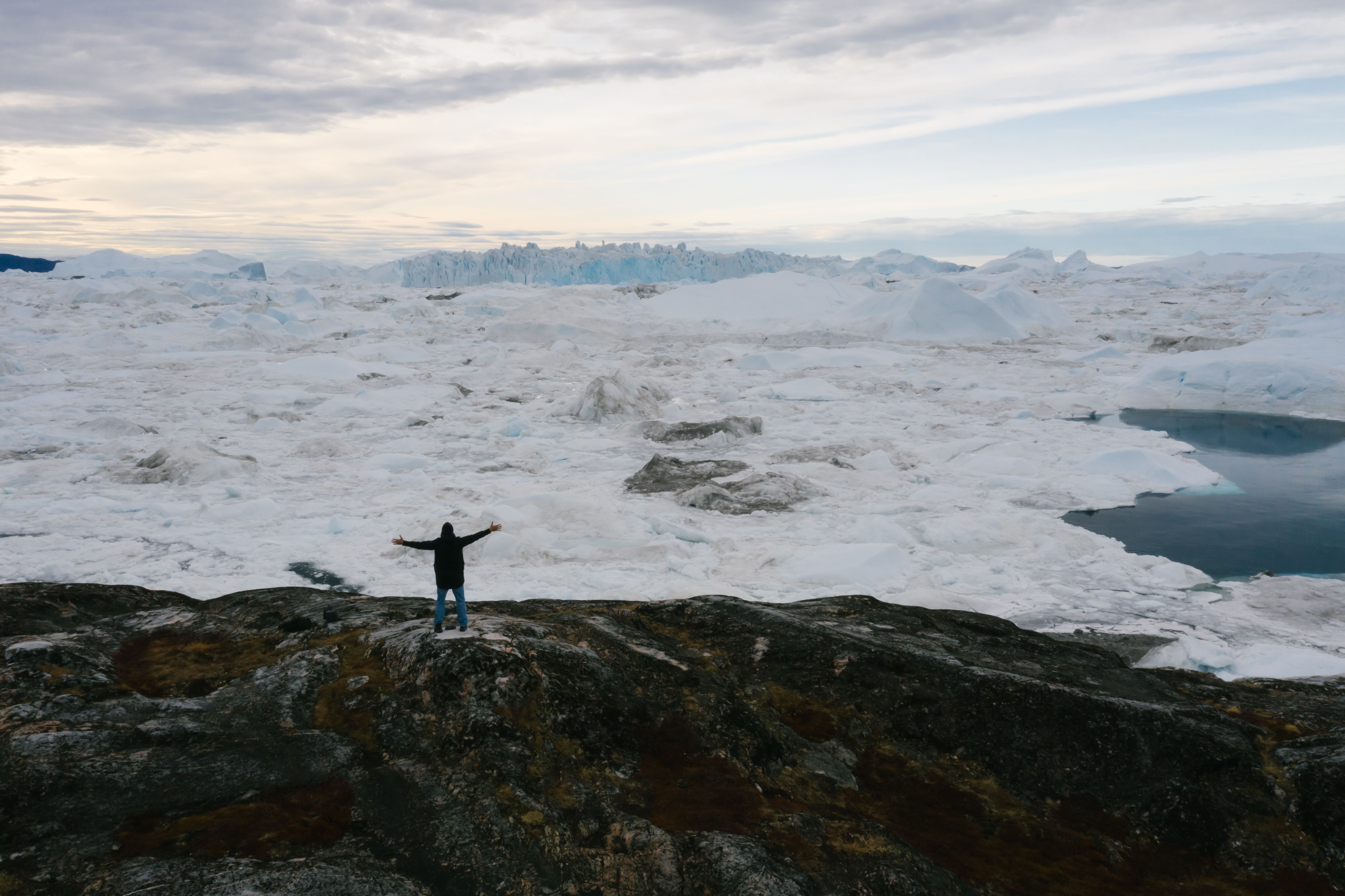 Person Standing on Rocks over Snow · Free Stock Photo