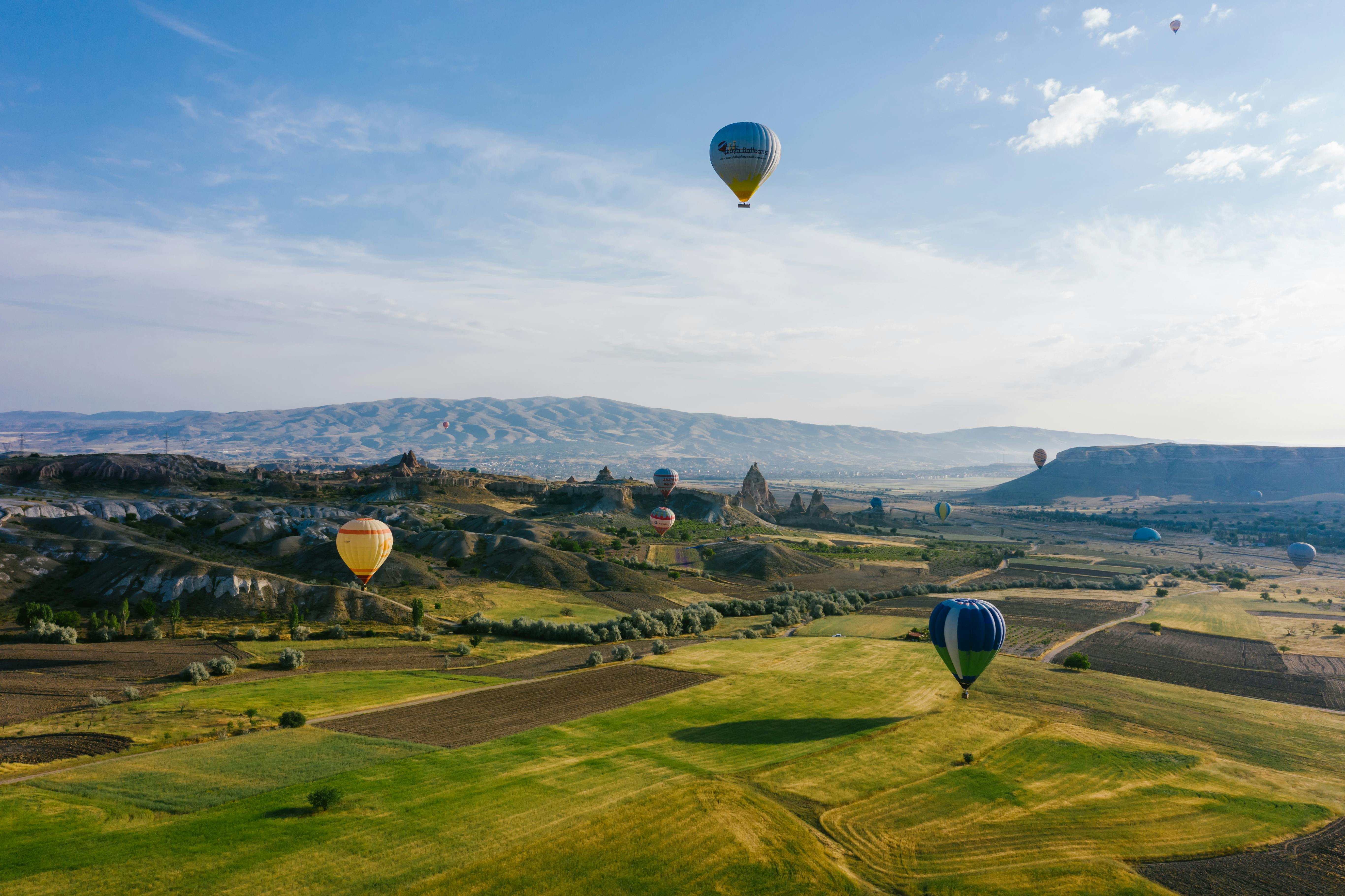 Hot Air Balloons Flying over Fields · Free Stock Photo