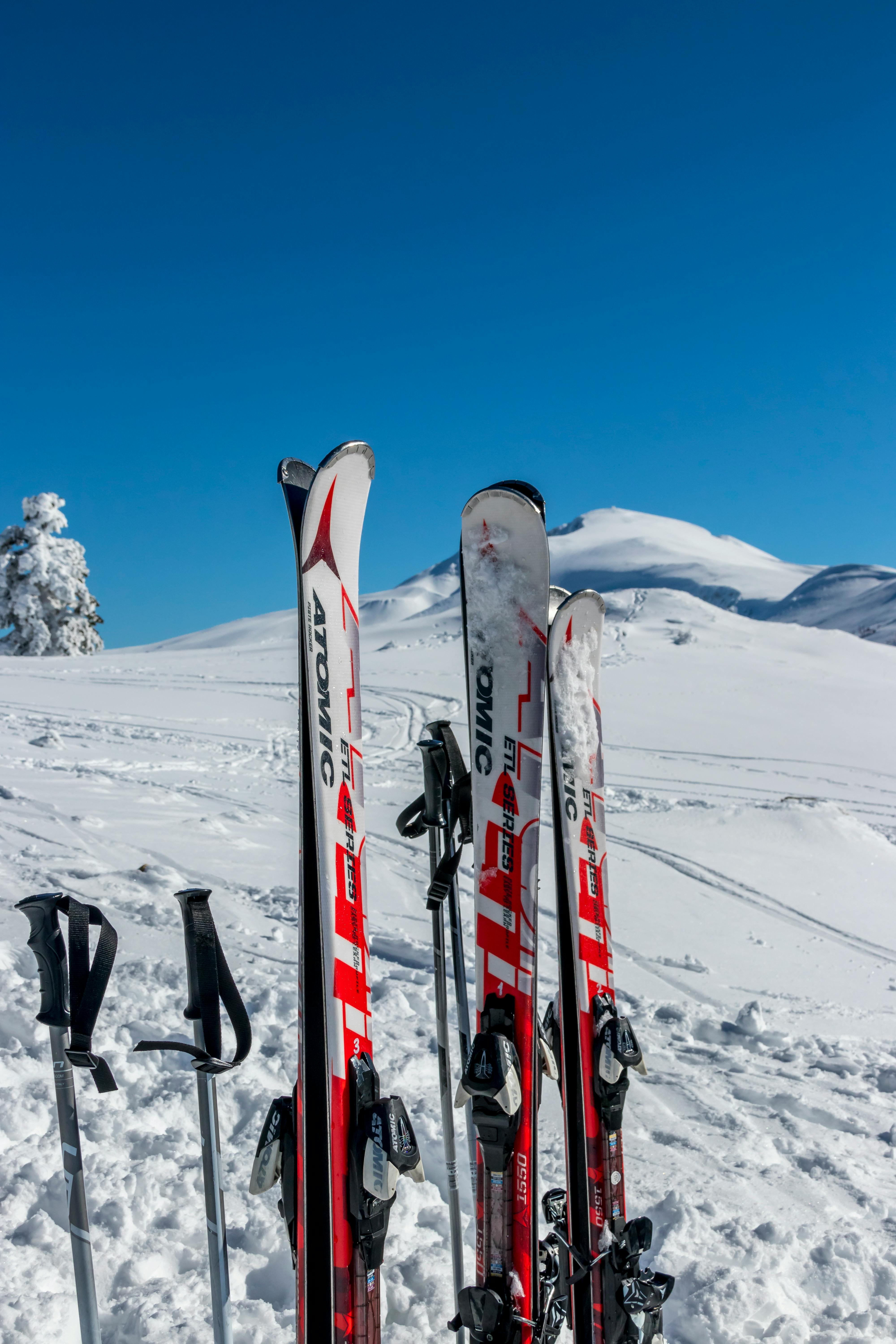 Skies Stacked in the Snow at Mountains · Free Stock Photo