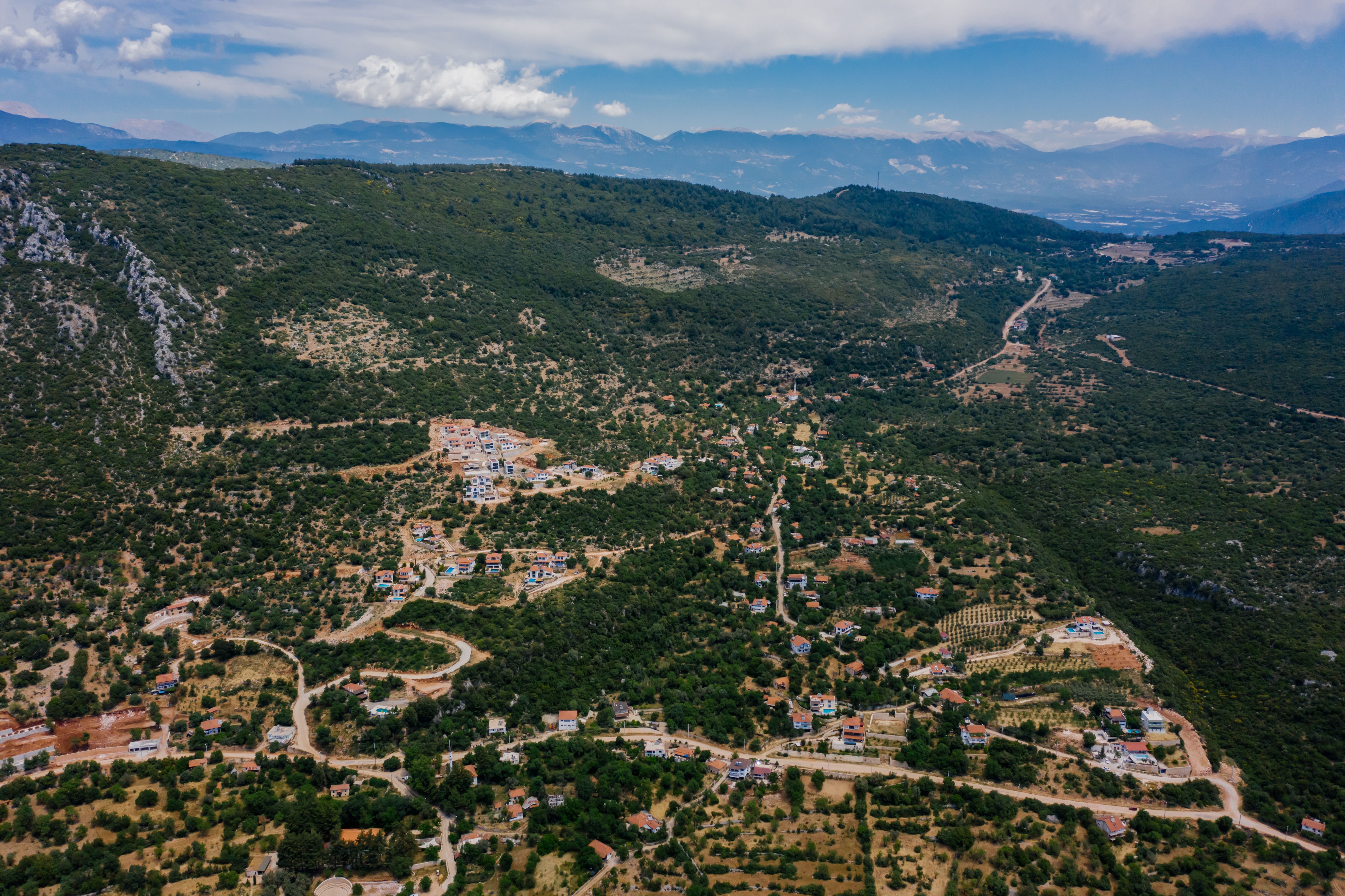 Aerial View of a Town between a Few Hills on a Flat Land · Free Stock Photo