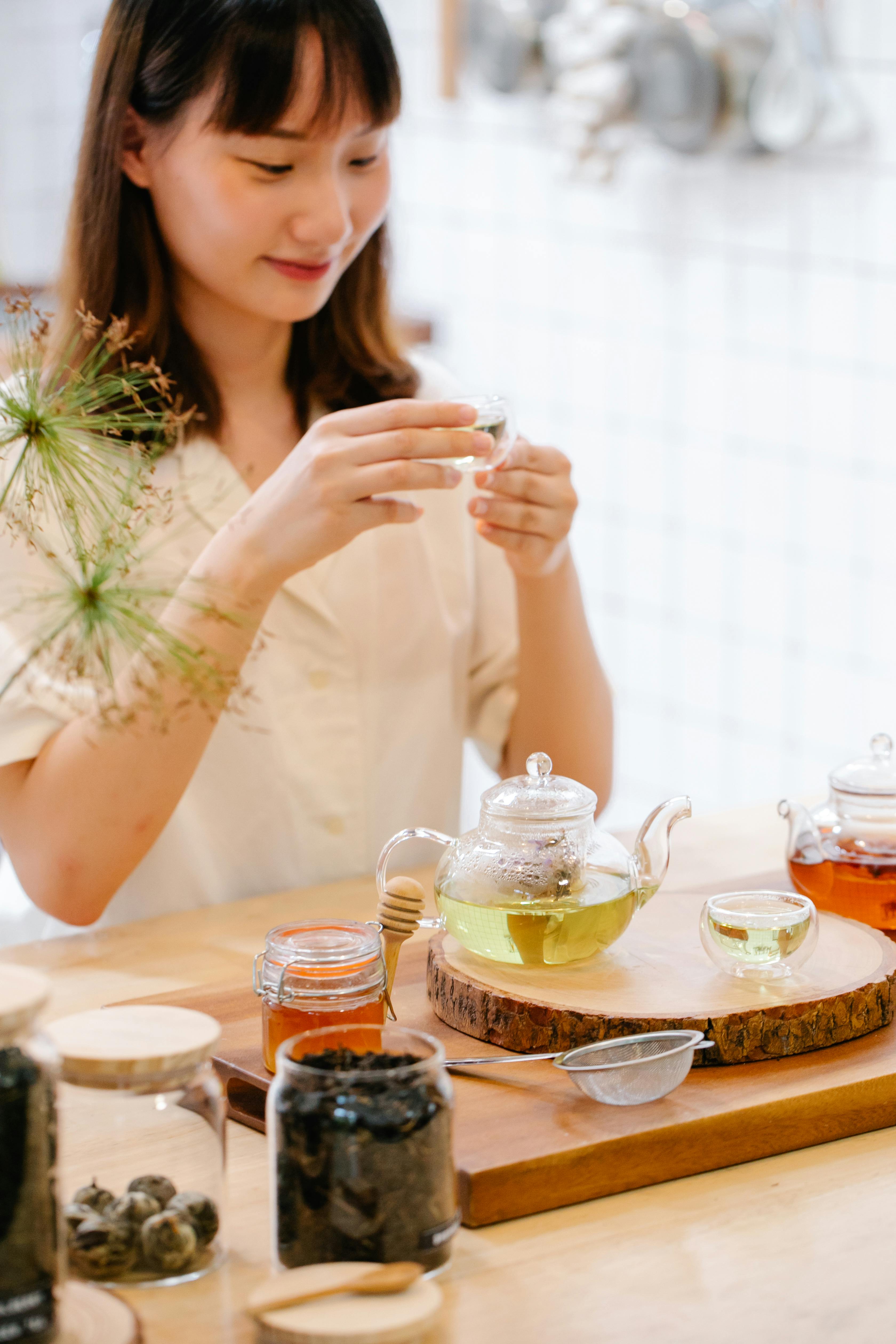 Smiling Woman Brewing Tea in Glass Teapots in the Kitchen · Free Stock ...