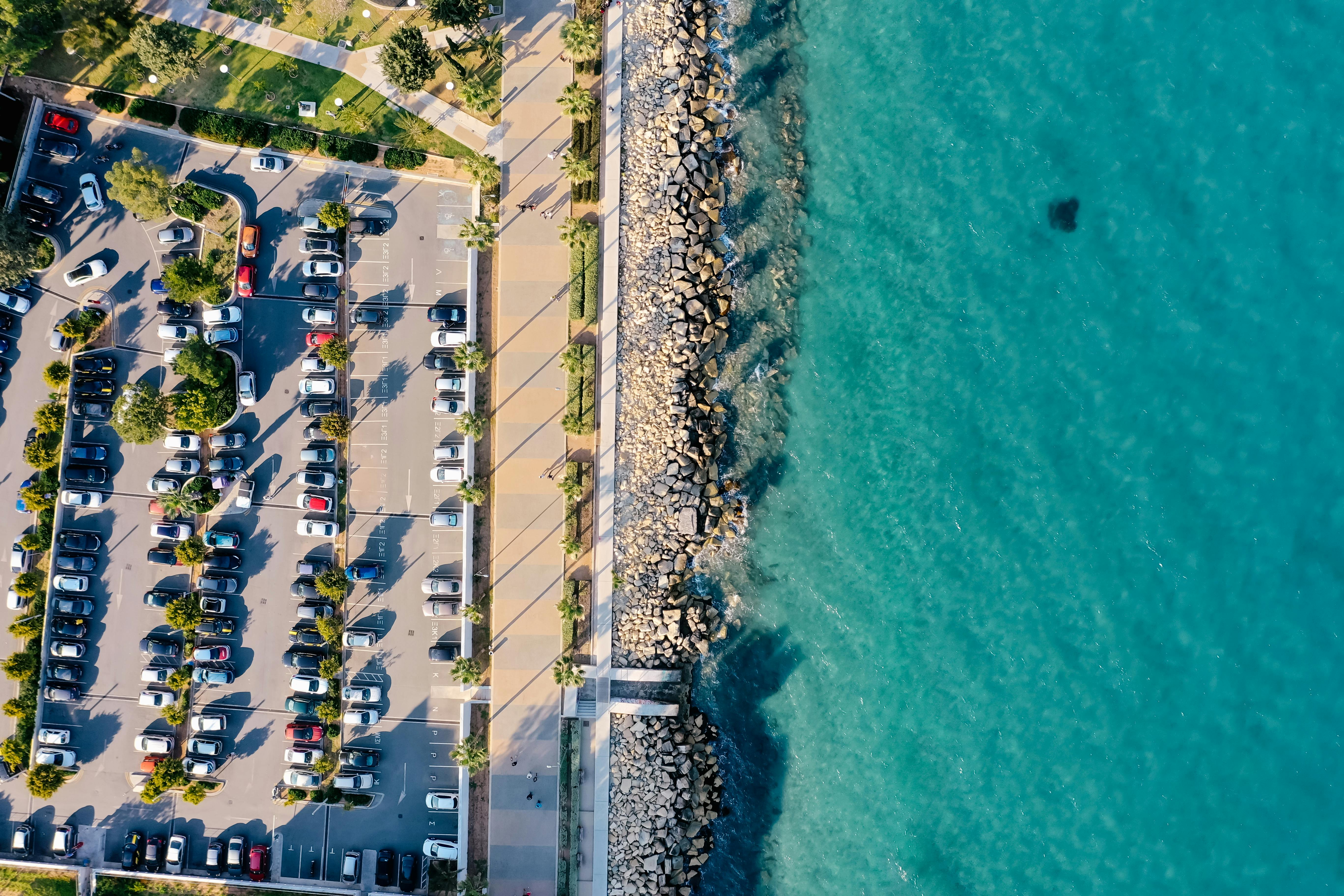 Parked Vehicles on a Parking Area Near a Body of Water · Free Stock Photo
