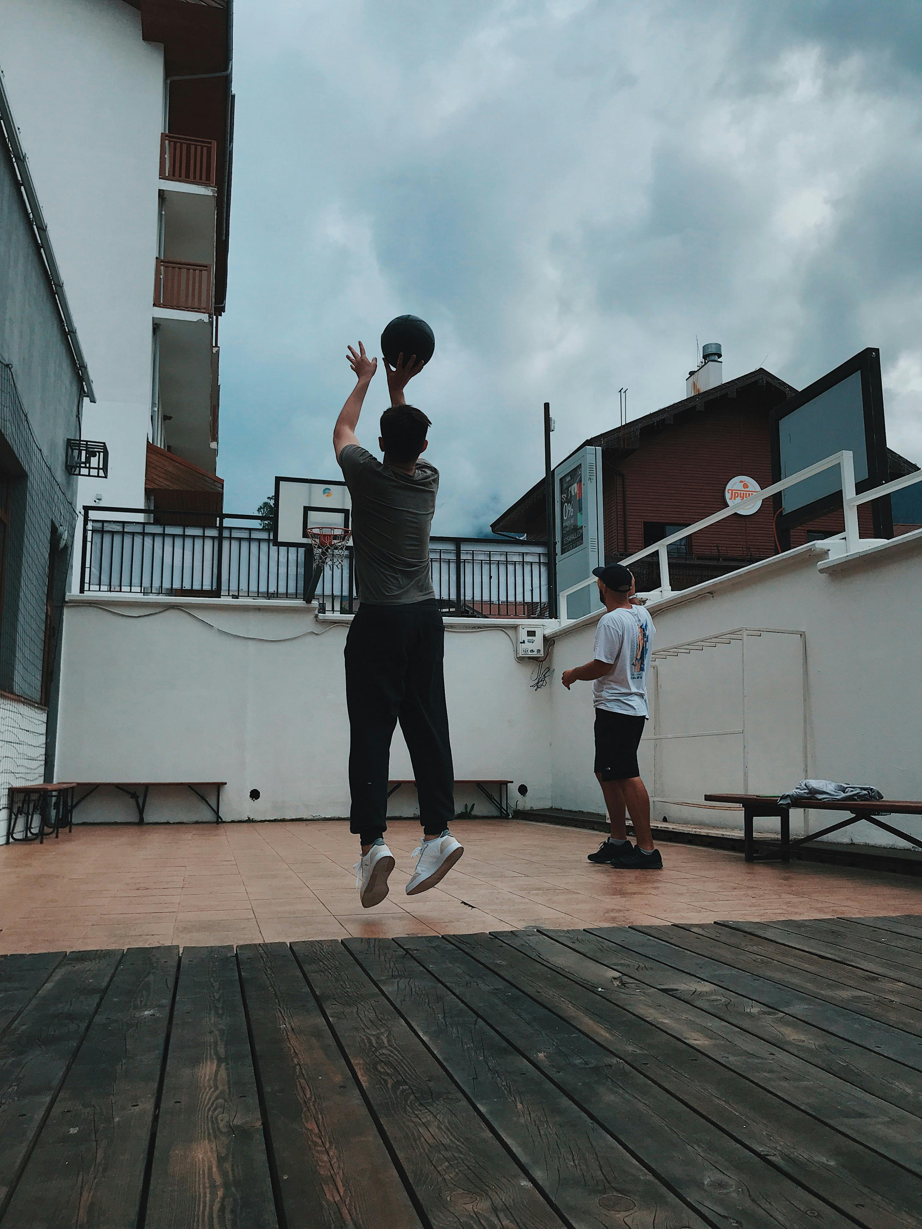Back View of a Woman Shooting a Basketball · Free Stock Photo