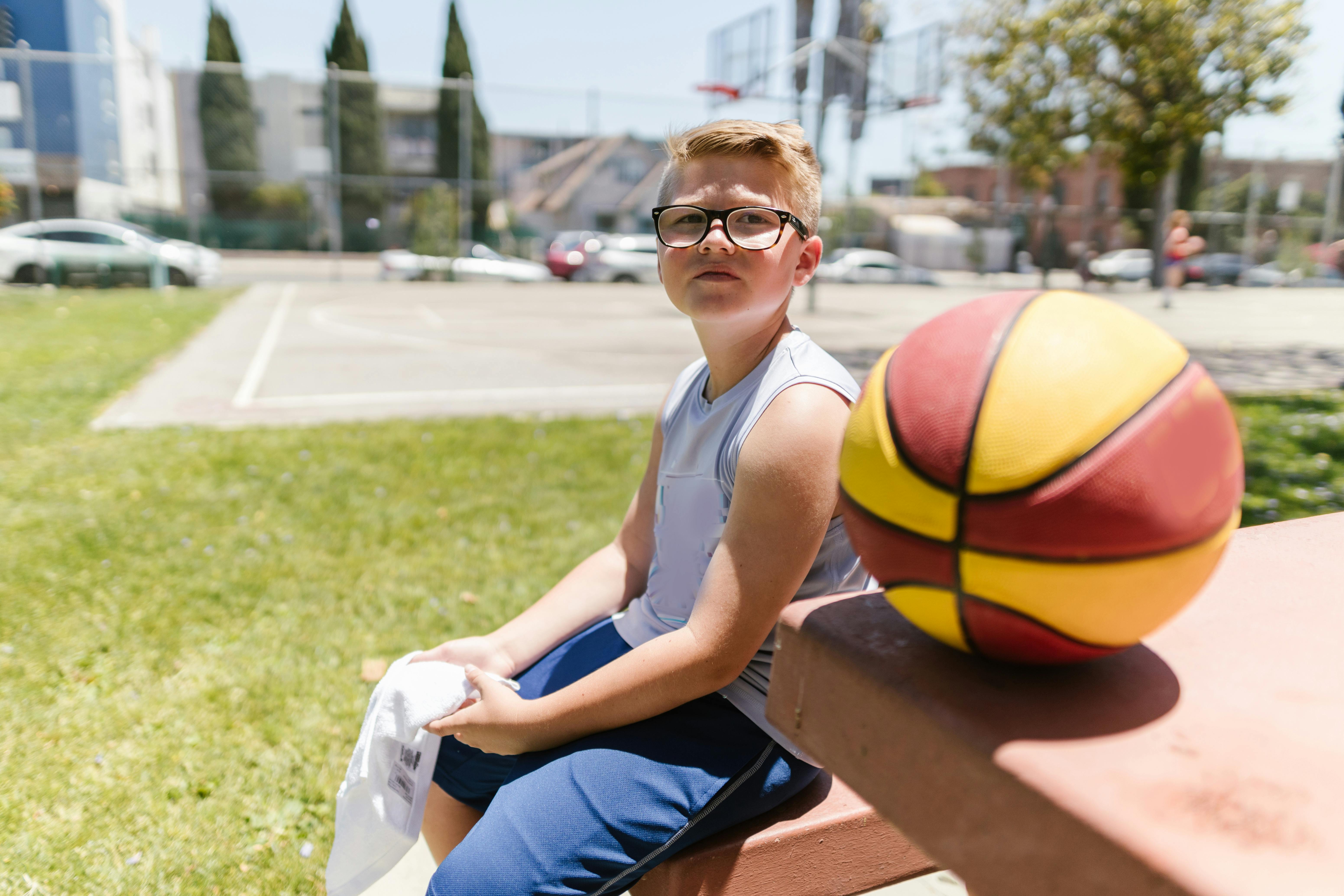 Boy seated under a Tree with Basketball beside him · Free Stock Photo