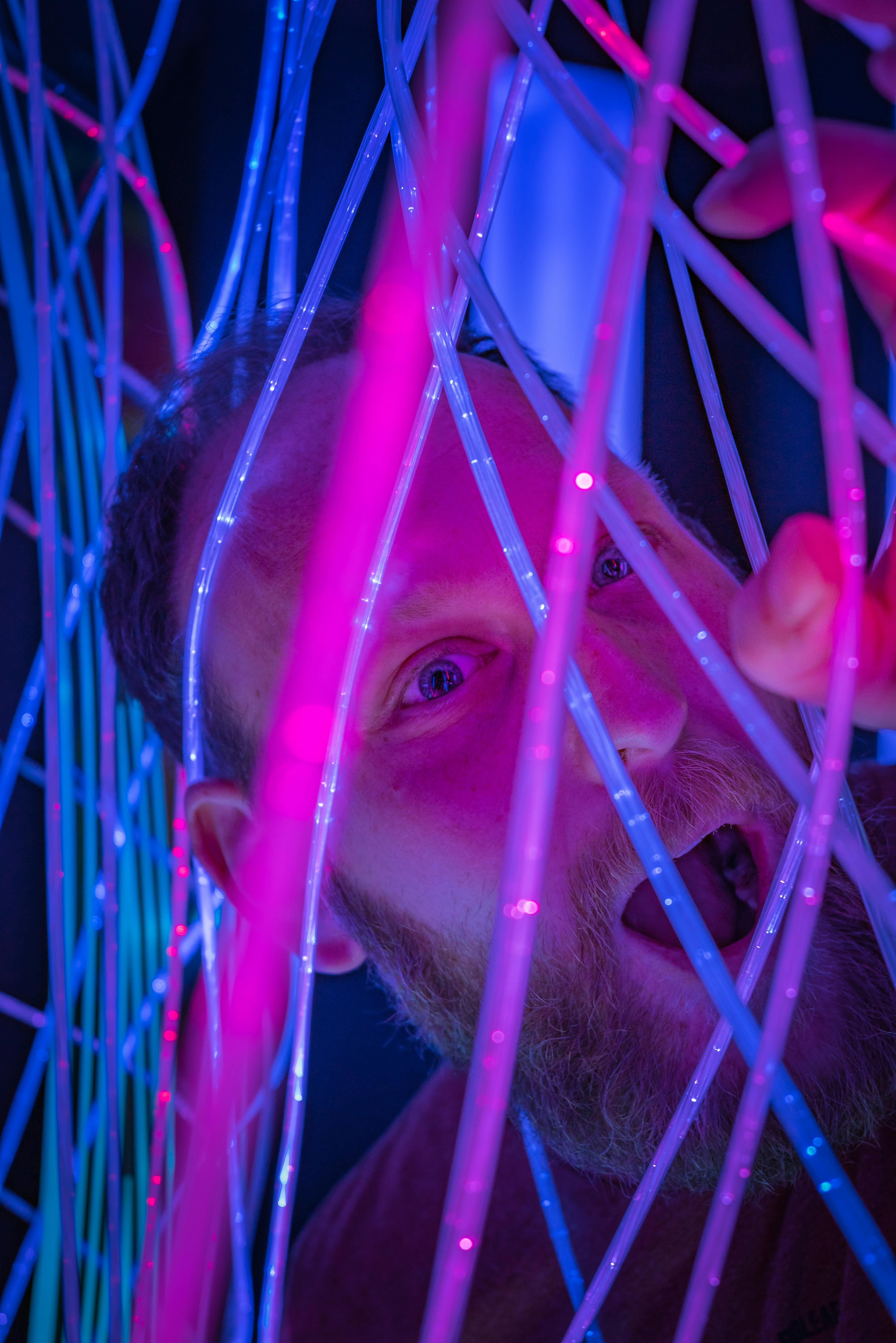Portrait of Man Hiding behind Neon Lights · Free Stock Photo