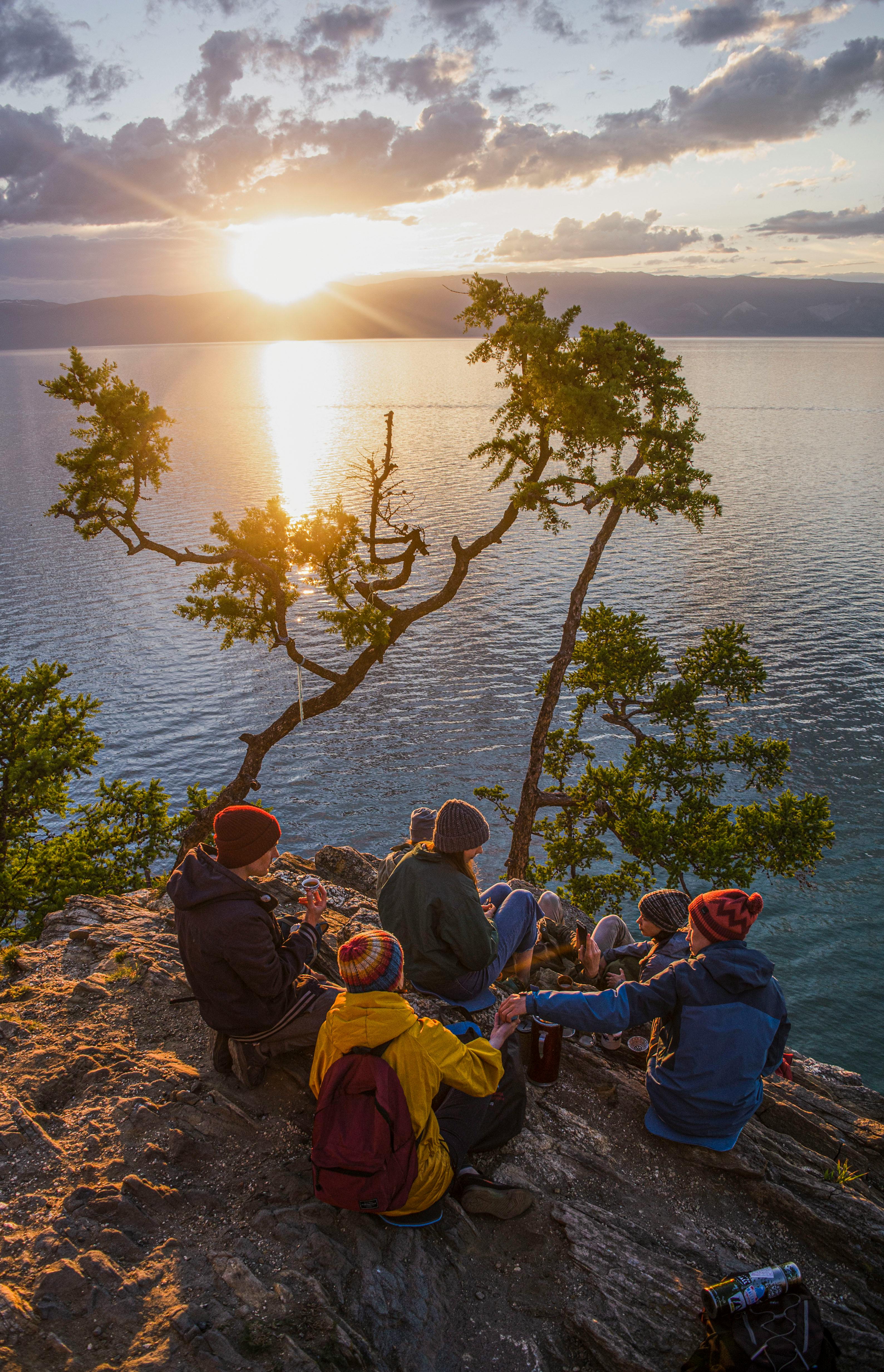 People Sitting on Ground Near Body of Water · Free Stock Photo