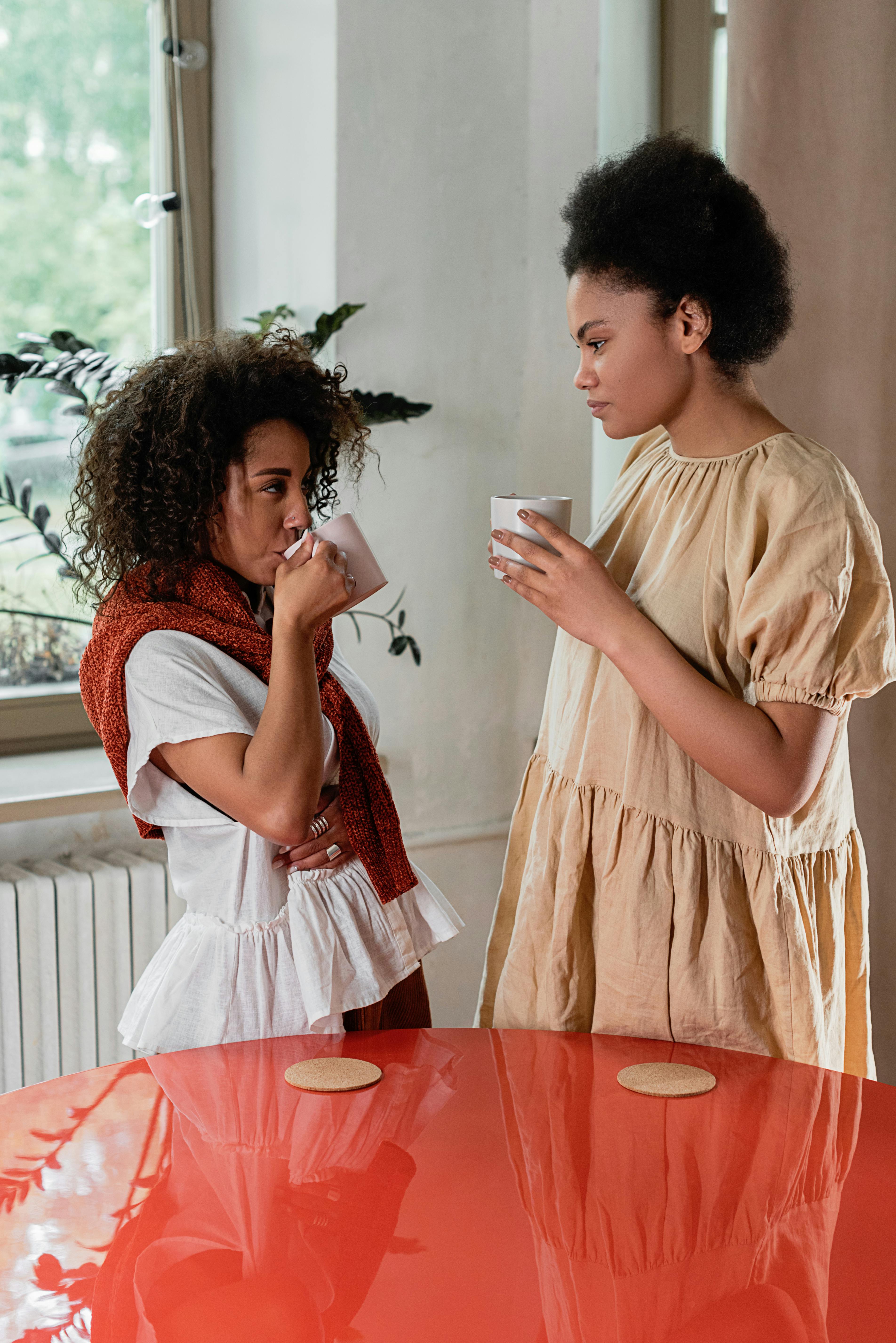Women Standing Near a Red Table · Free Stock Photo