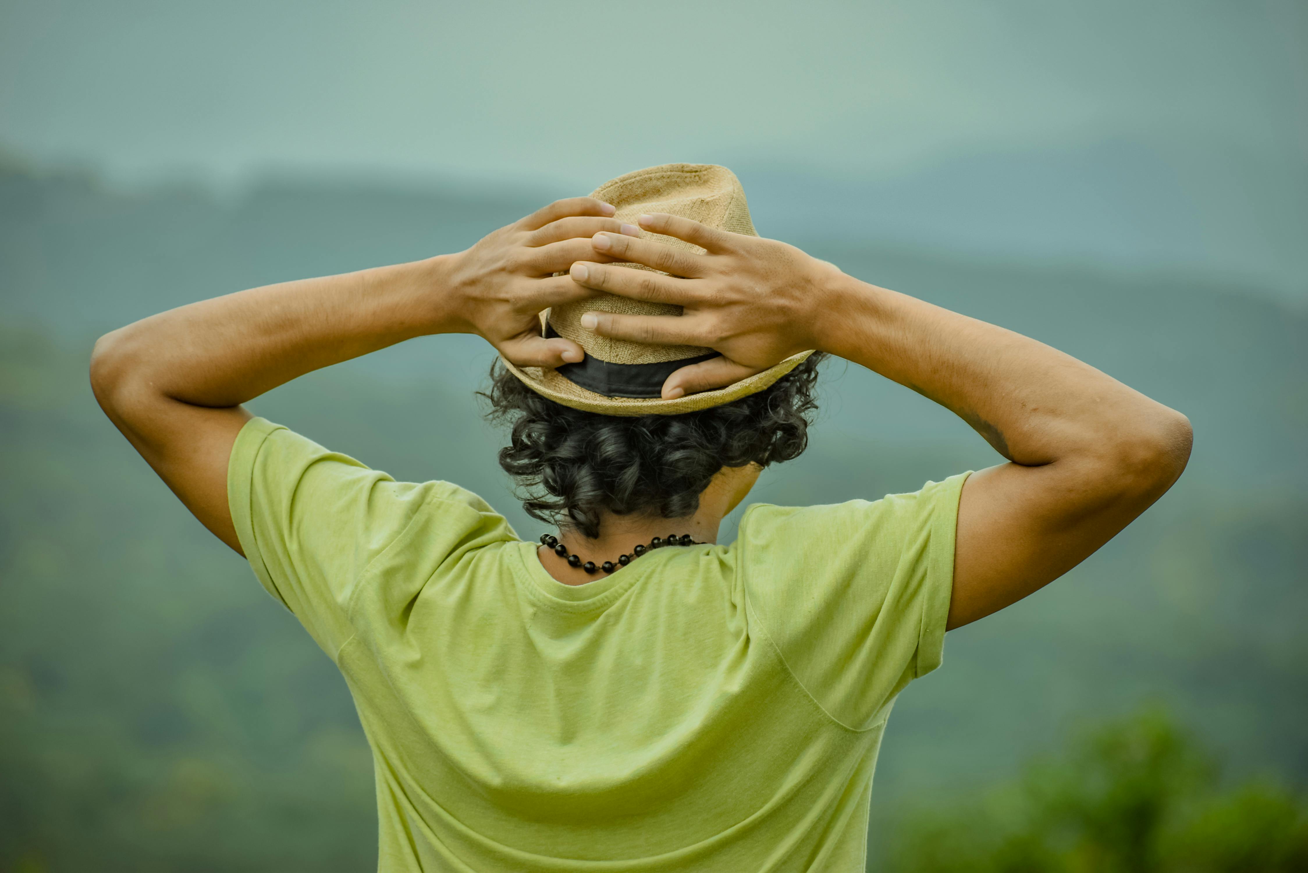 Back View of a Man with Both His Hands on the Back of His Head Looking ...